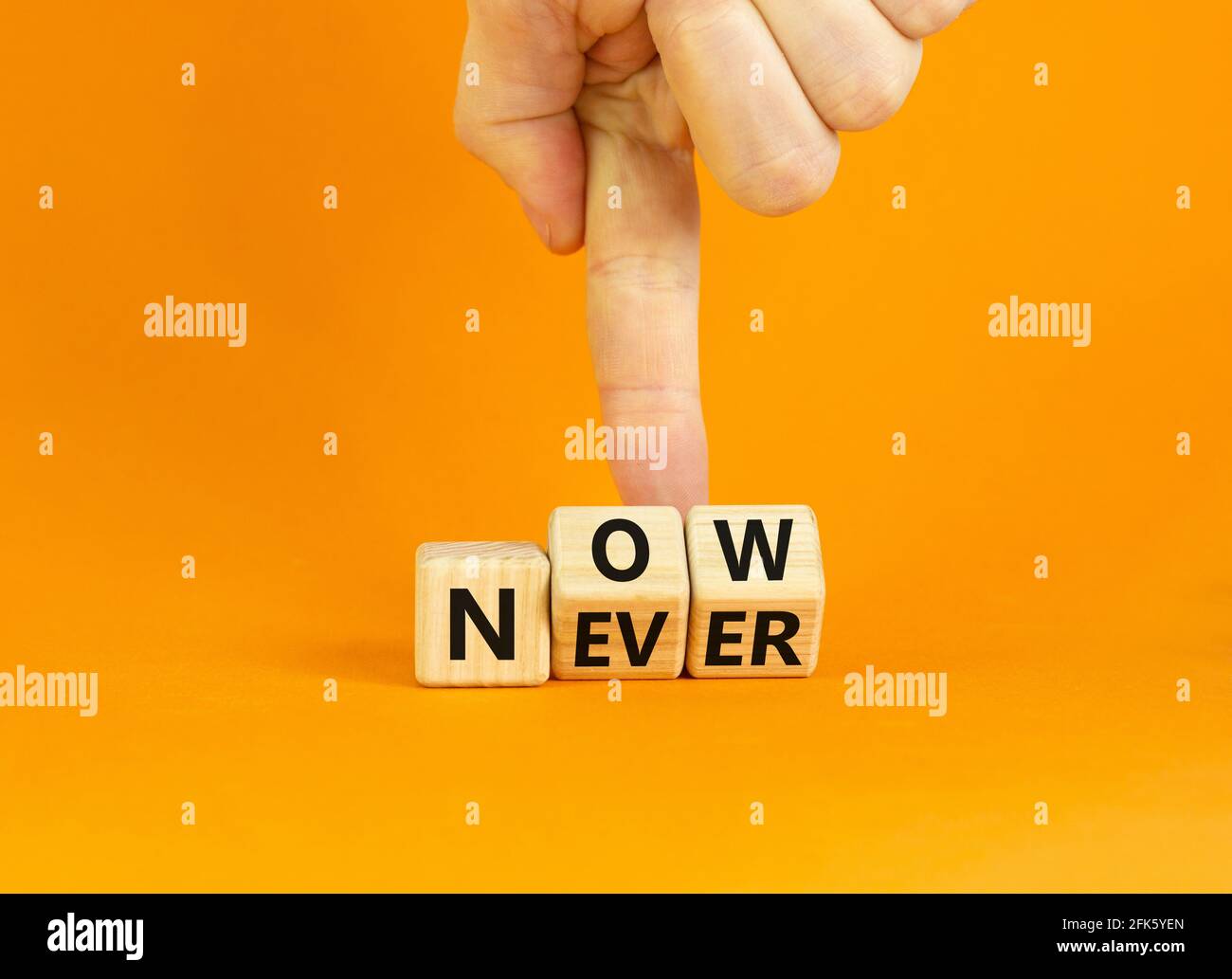 Now or never symbol. Businessman turns wooden cubes and changes the ...