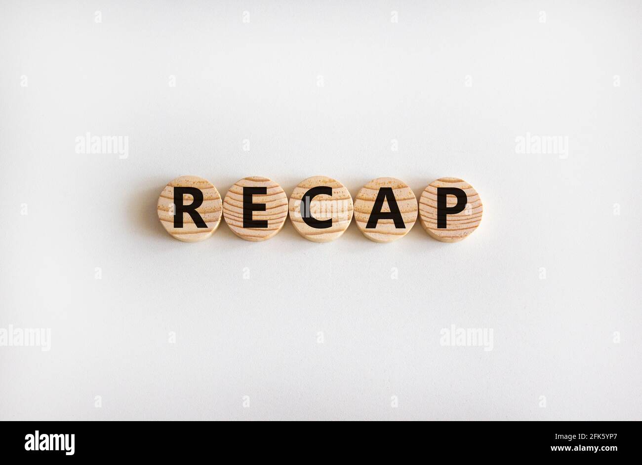 Recap symbol. The word 'recap' on wooden circles on beautiful white ...