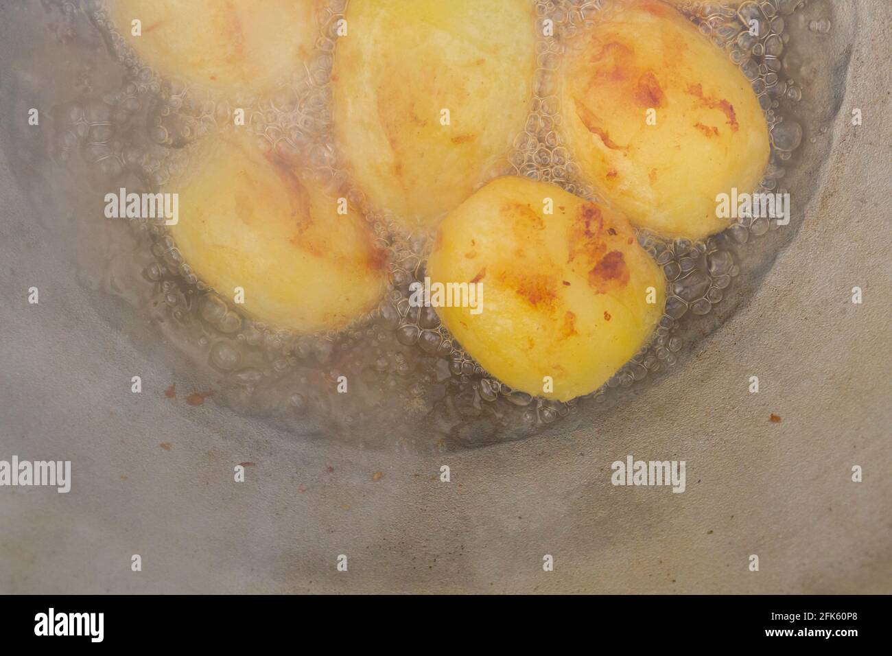 Golden potatoes are fried in boiling oil in a cauldron Stock Photo - Alamy