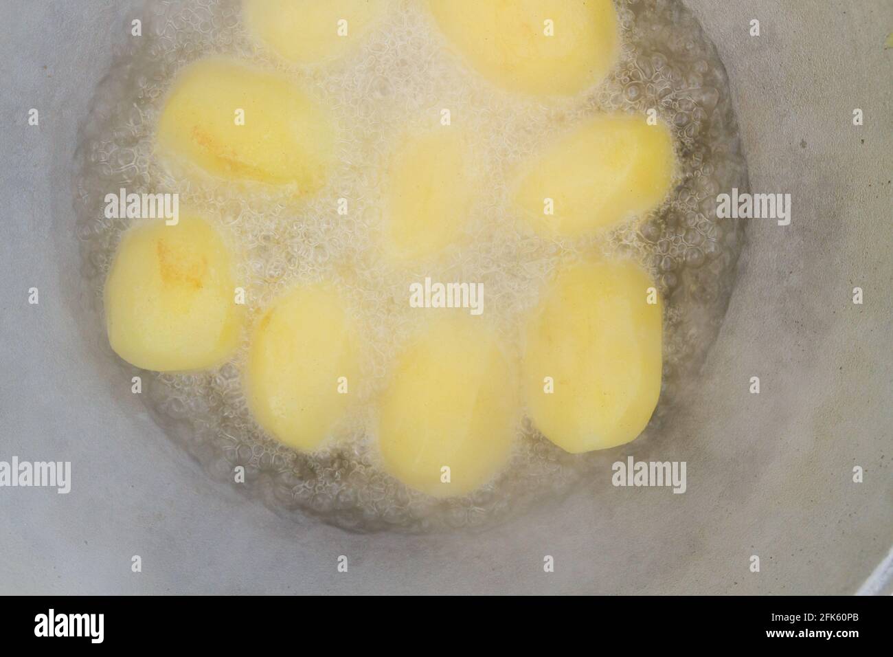 Golden potatoes are fried in boiling oil in a cauldron Stock Photo - Alamy