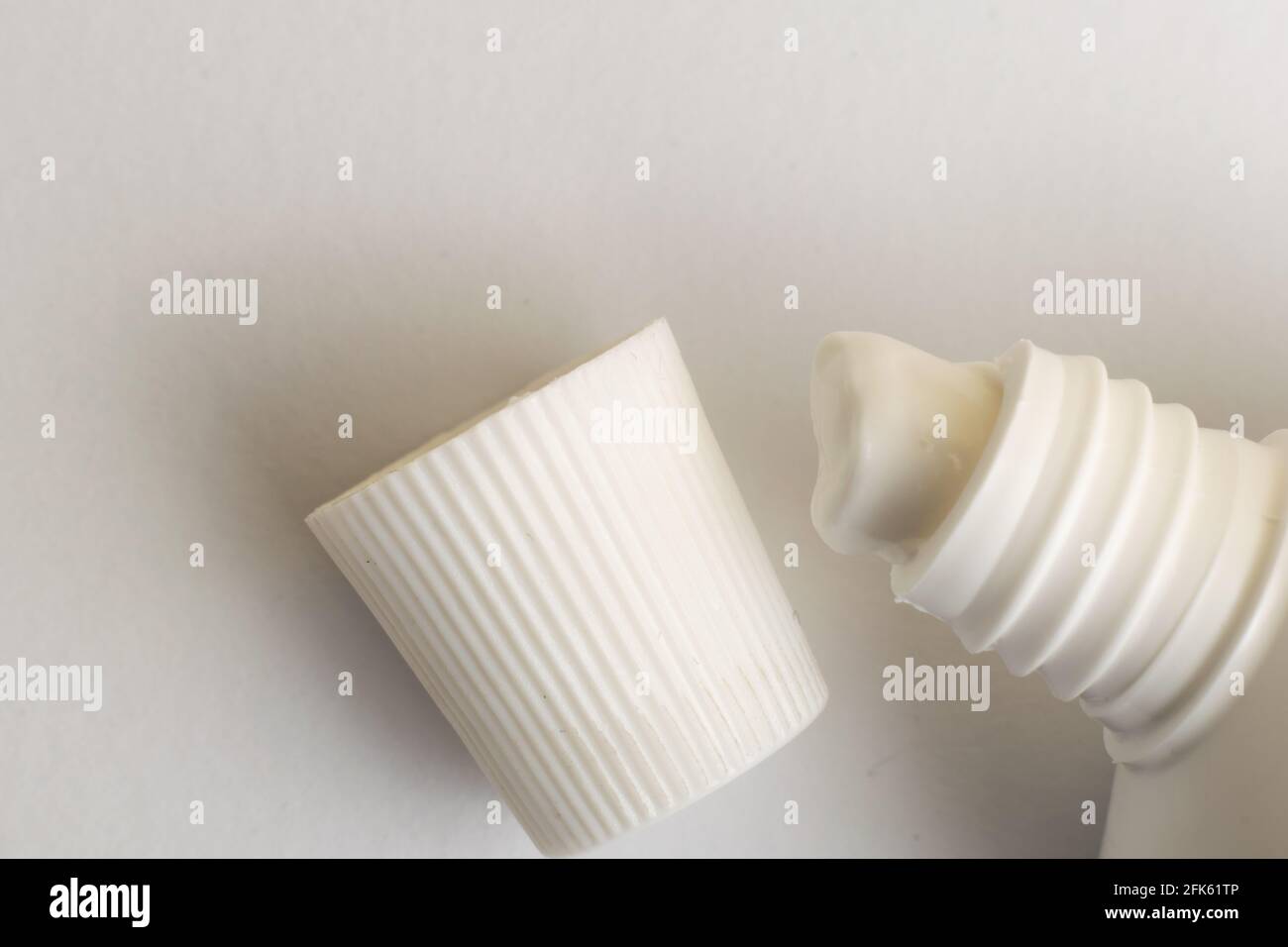 Open white toothpaste canister coming out paste on white Stock Photo ...