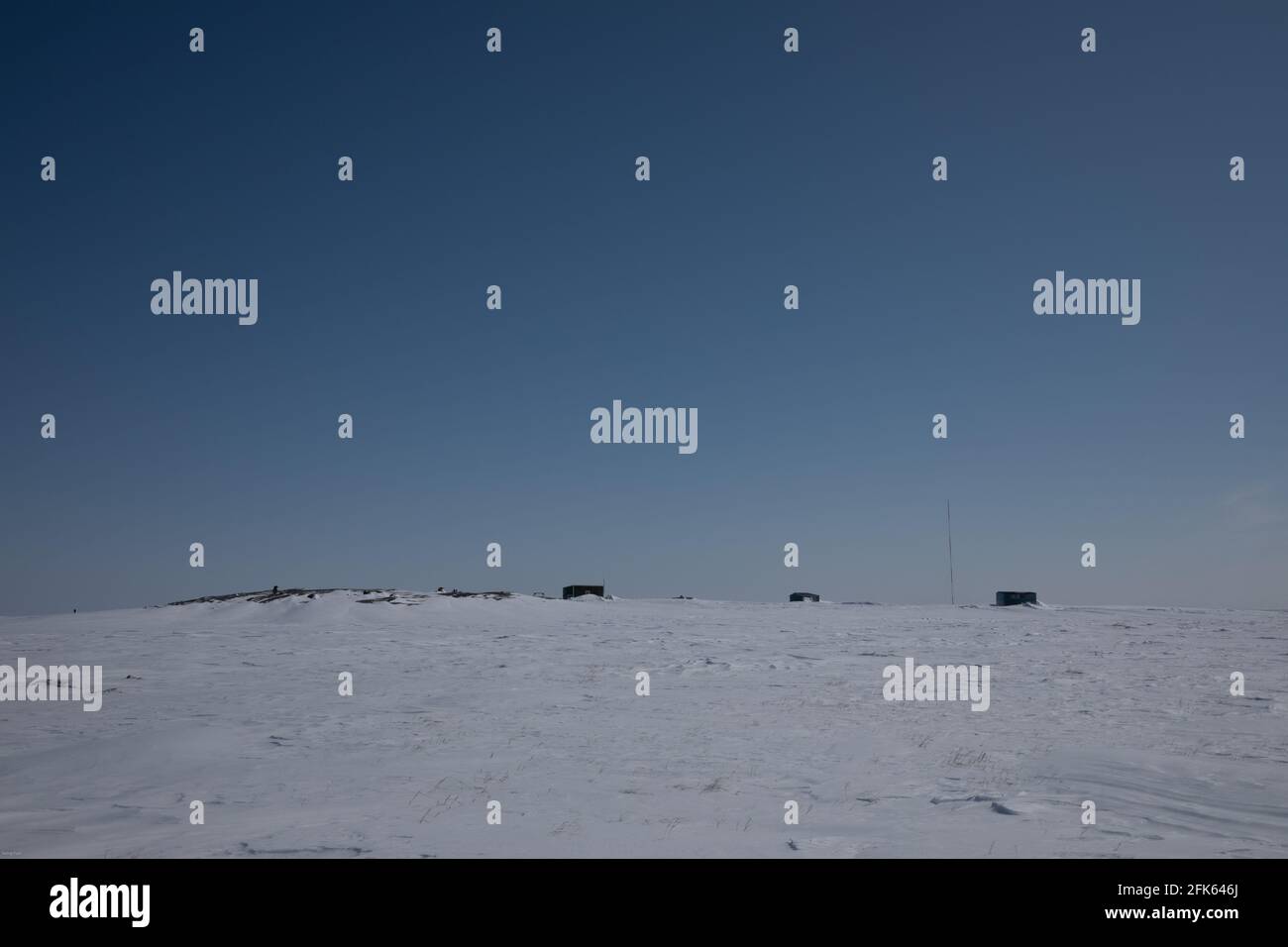 Frozen arctic landscape with snow on the ground with buildings in the ...