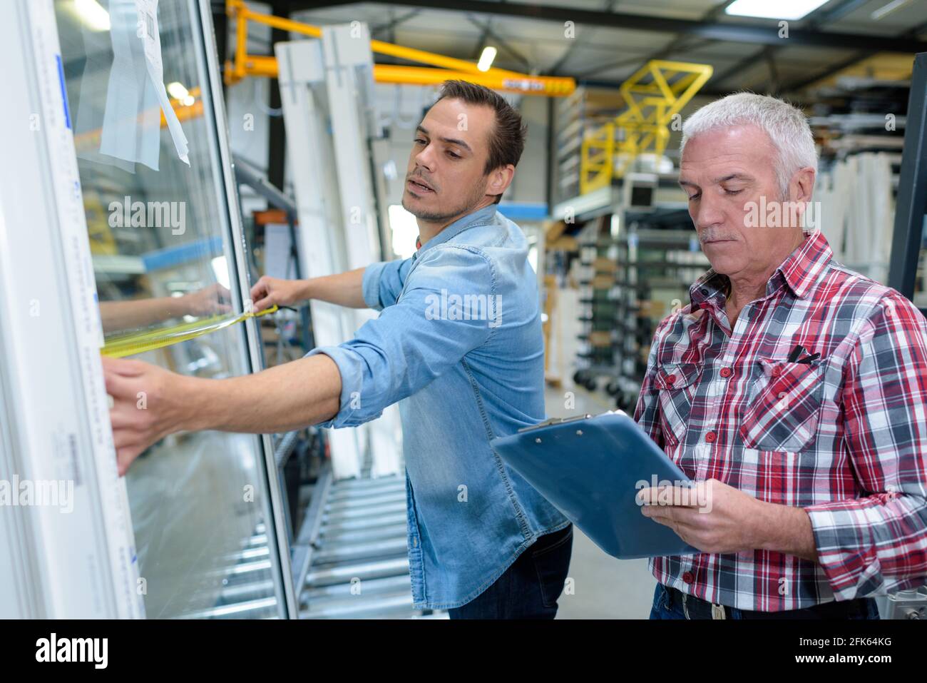 man using measuring tape in production of pvc windows Stock Photo - Alamy