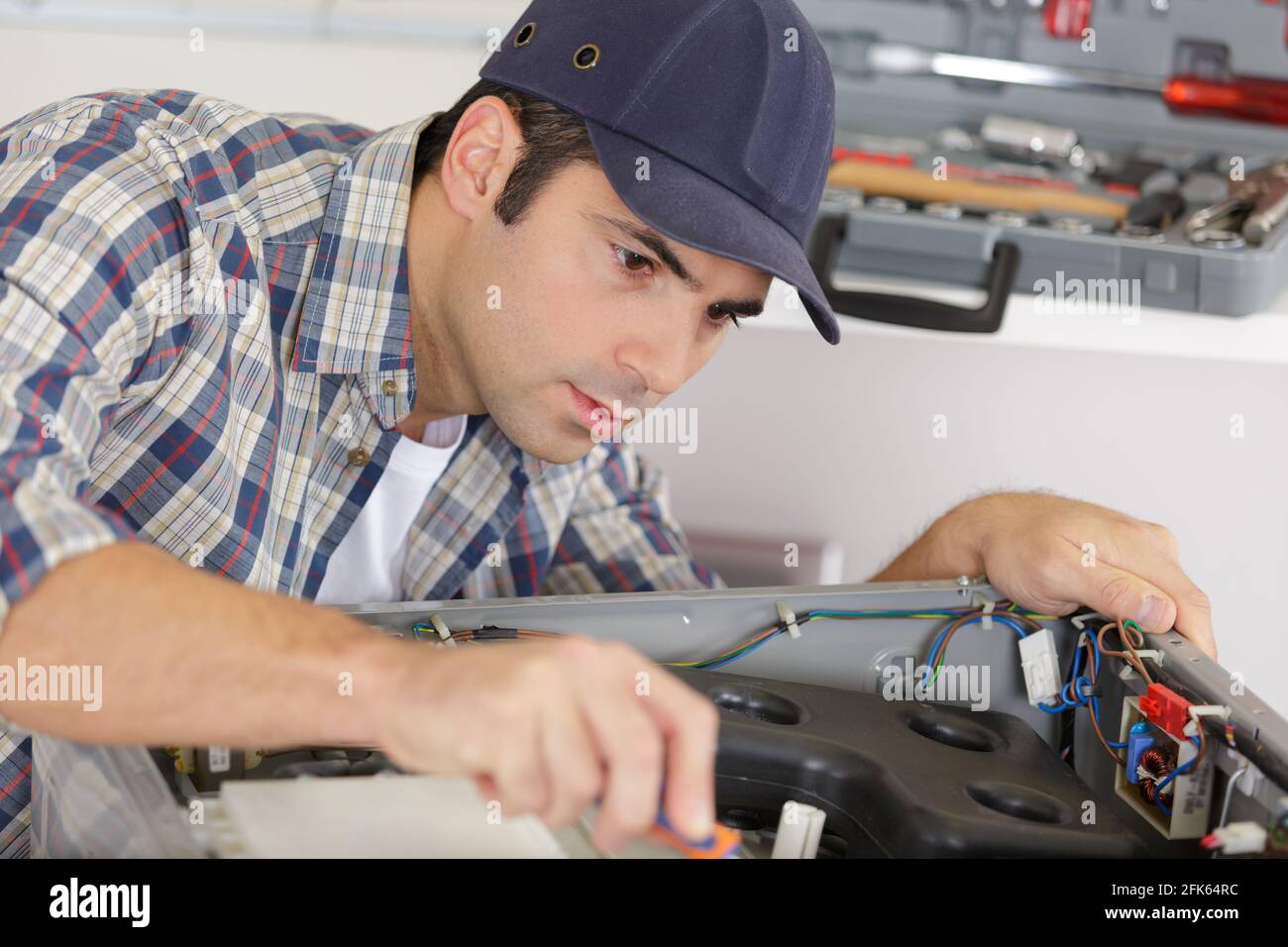 man fixing a washing machine Stock Photo - Alamy