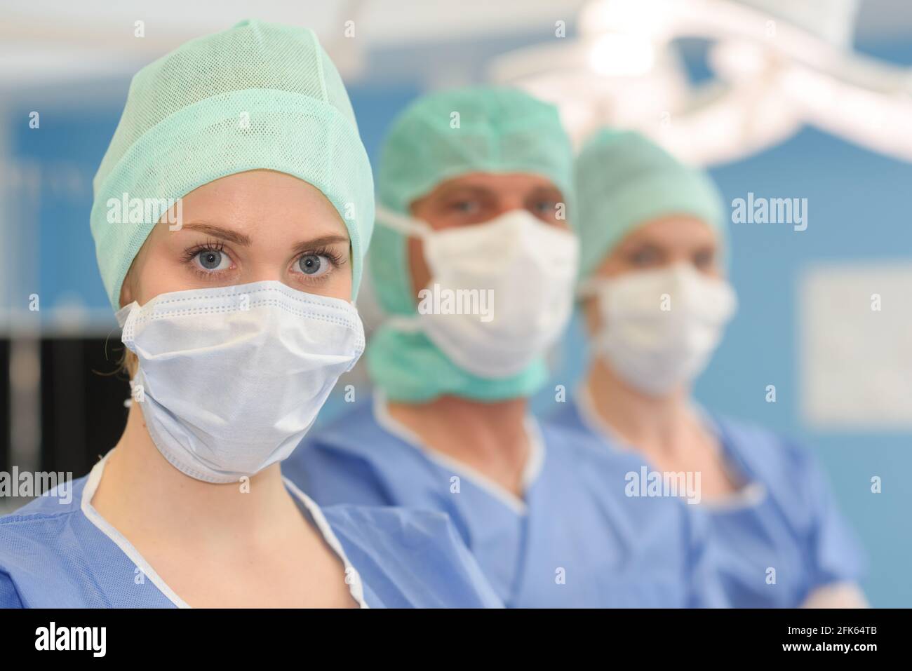 three surgeons at work operating in surgical theatre Stock Photo - Alamy