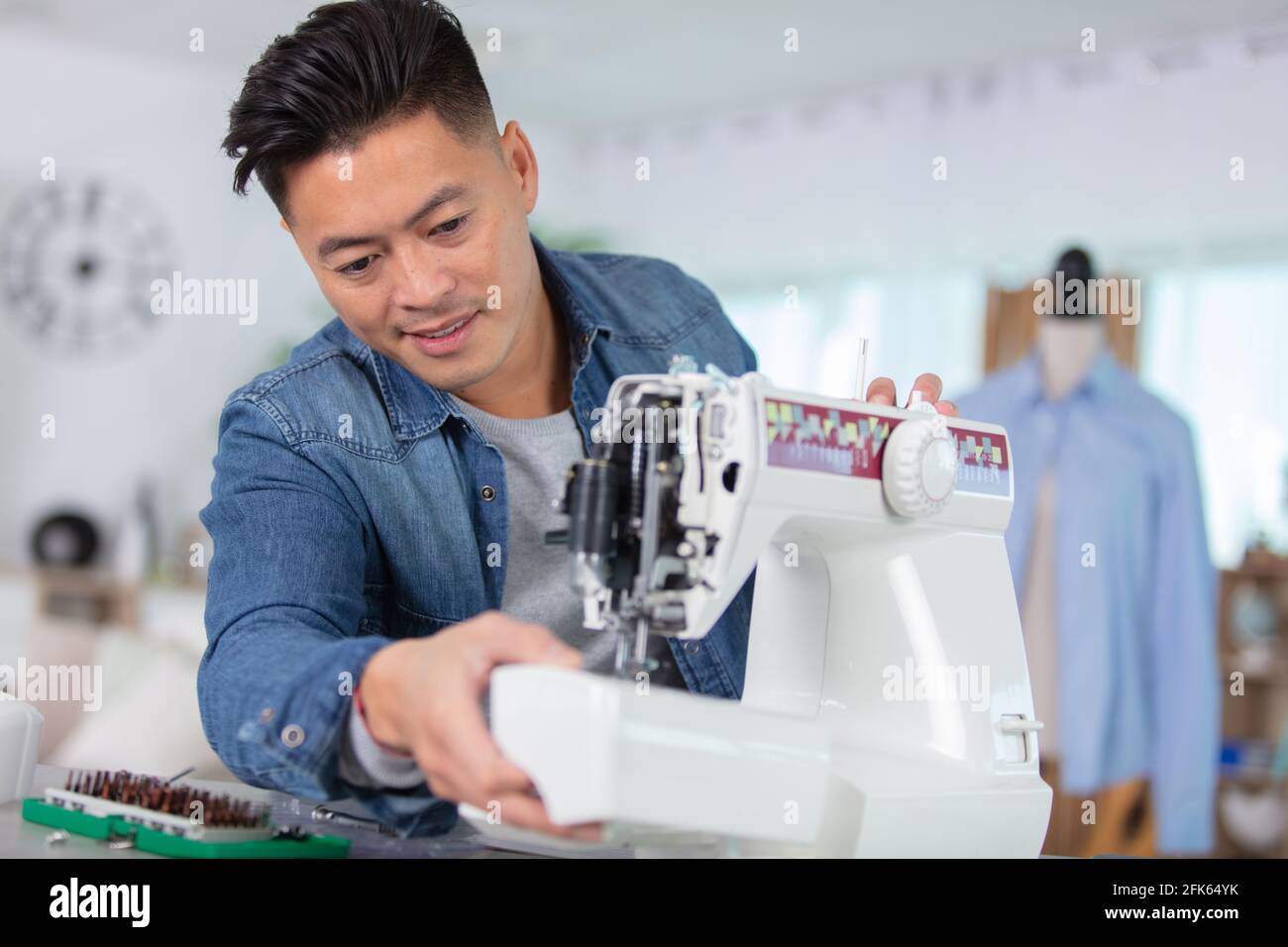 handsome fashion designer sewing with a sewing machine Stock Photo - Alamy