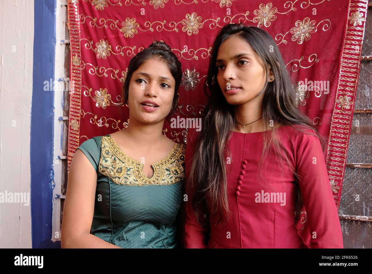 Low angle shot of two young Indian female friends talking to each other ...