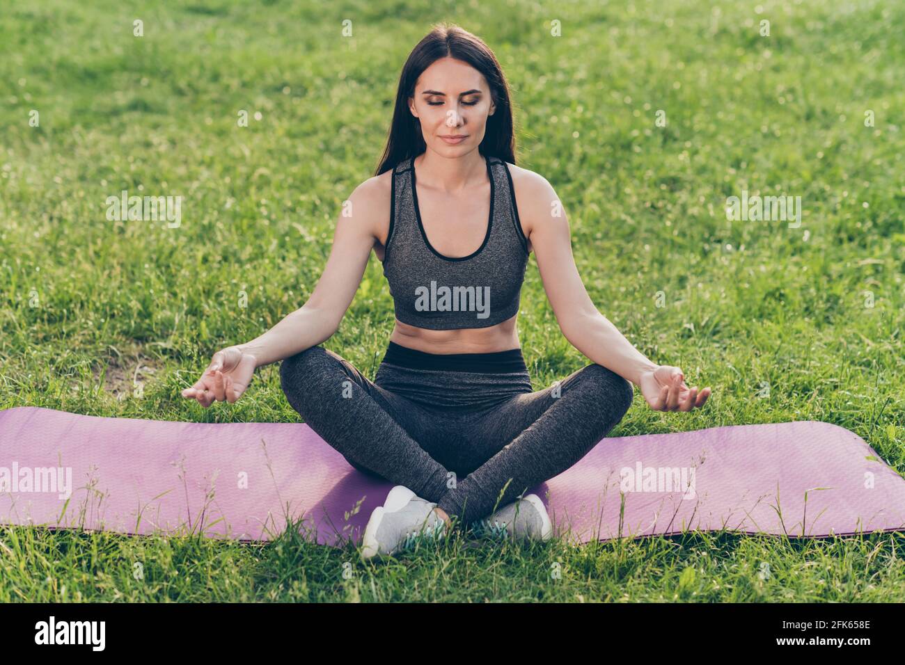 Full body photo of attractive person sit on fitness carpet closed eyes ...