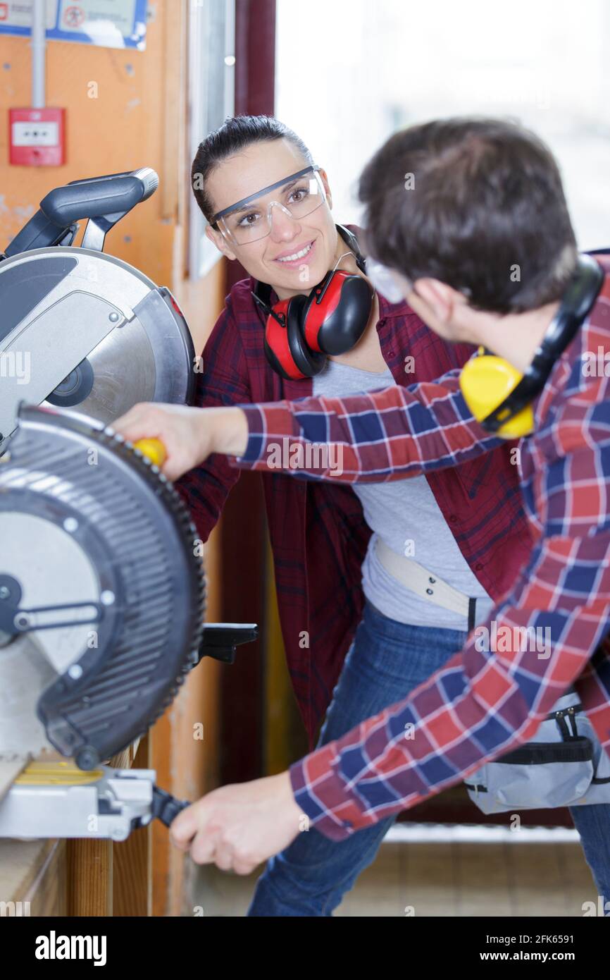 portrait of mature carpenter helping young worker sawing wood Stock ...