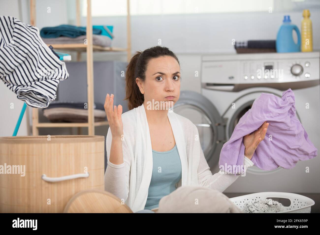 sad woman having a lot of laundry to make Stock Photo - Alamy