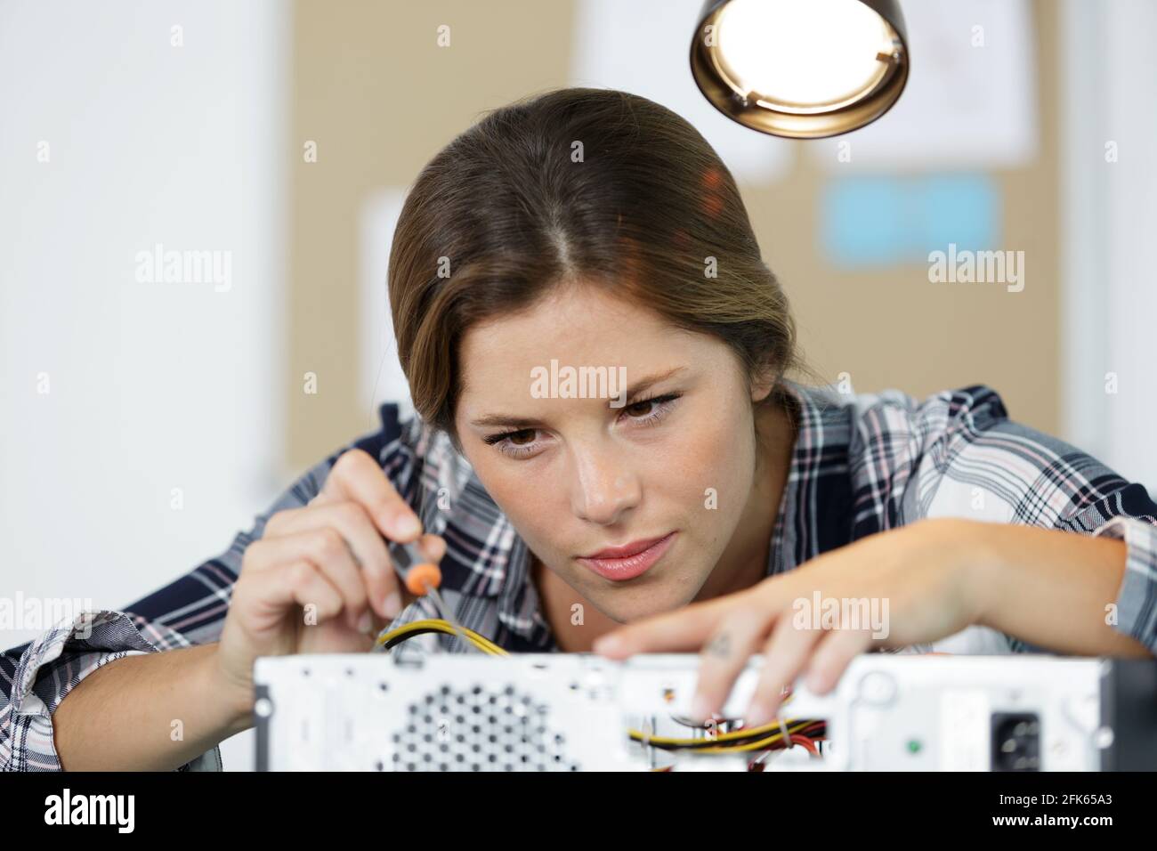 pretty young woman repairing a pc Stock Photo - Alamy