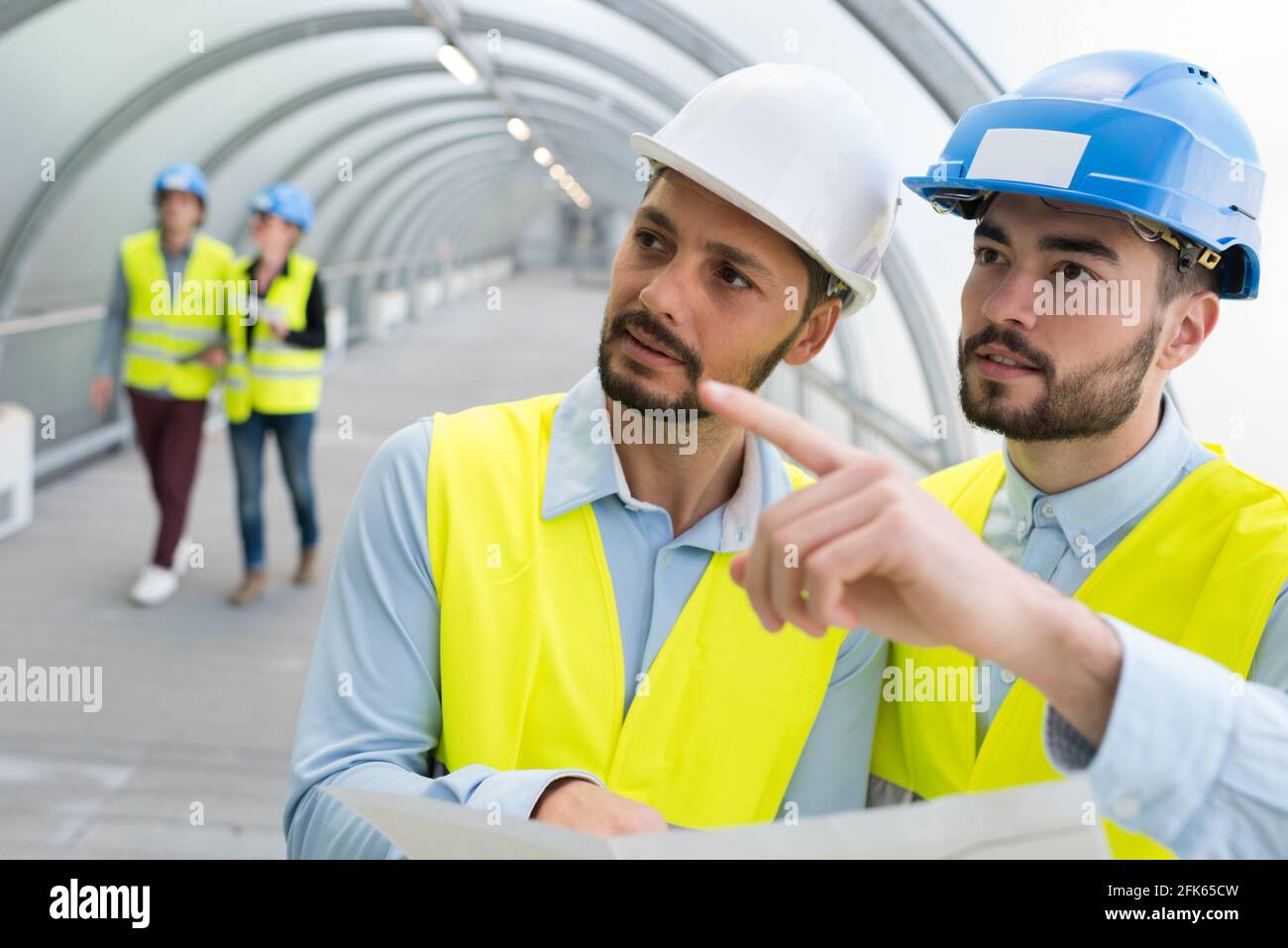 portrait of contractors pointing at something Stock Photo - Alamy