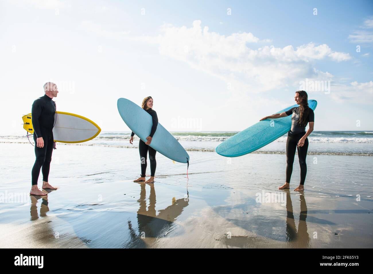 Group of surfer friends during a summer sunrise surf Stock Photo - Alamy