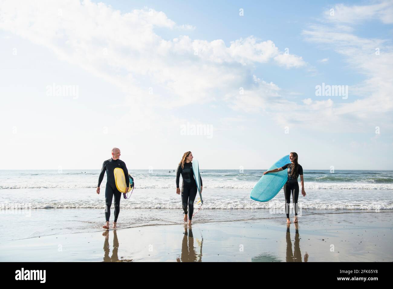 Group of surfer friends during a summer sunrise surf Stock Photo - Alamy
