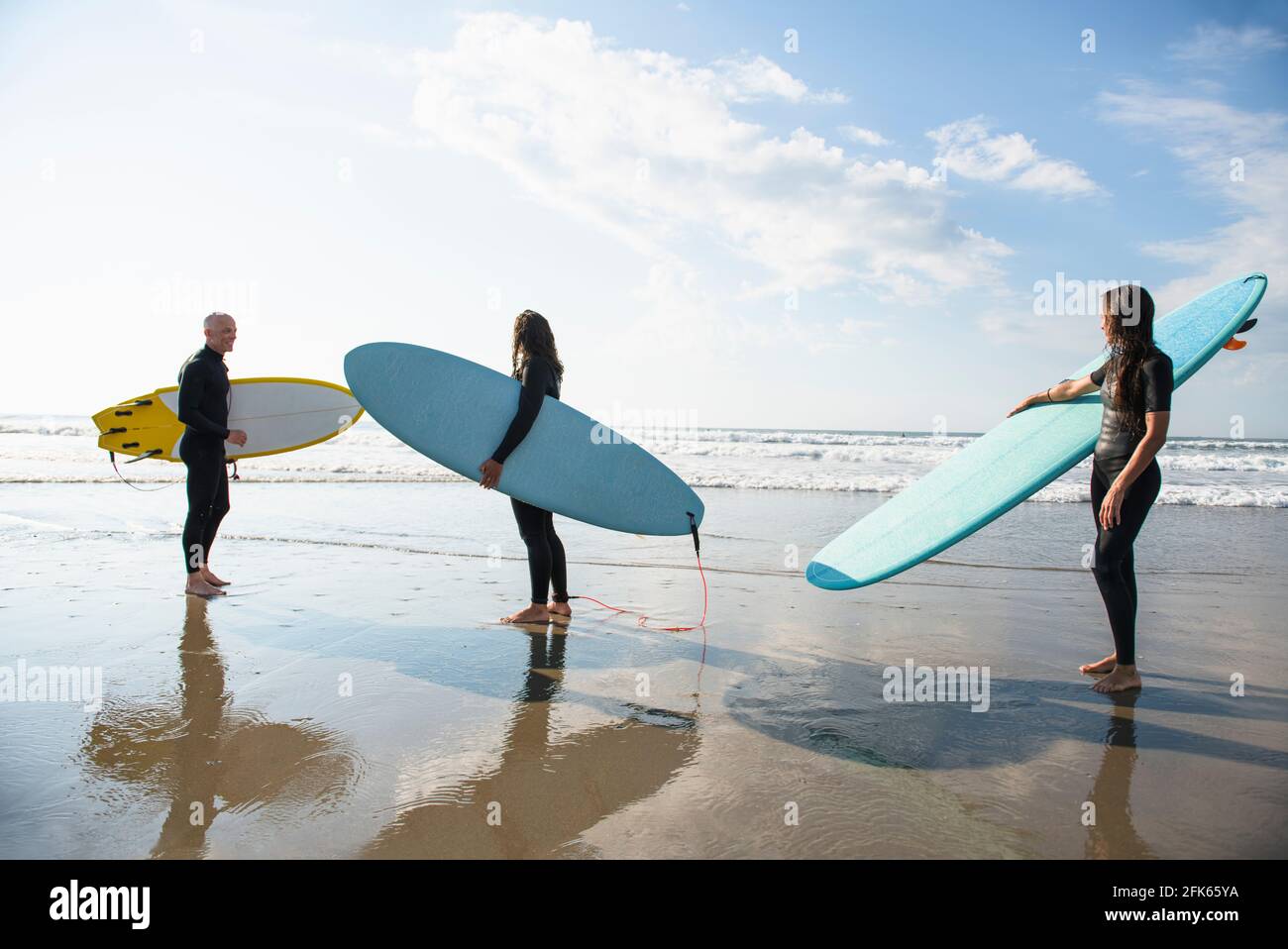 Group of surfer friends during a summer sunrise surf Stock Photo - Alamy