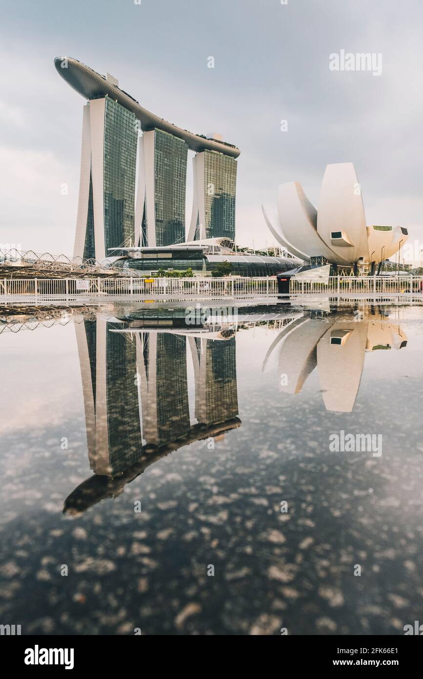 Marina Bay Sands and ArtScience Museum reflected in a rain puddle in ...