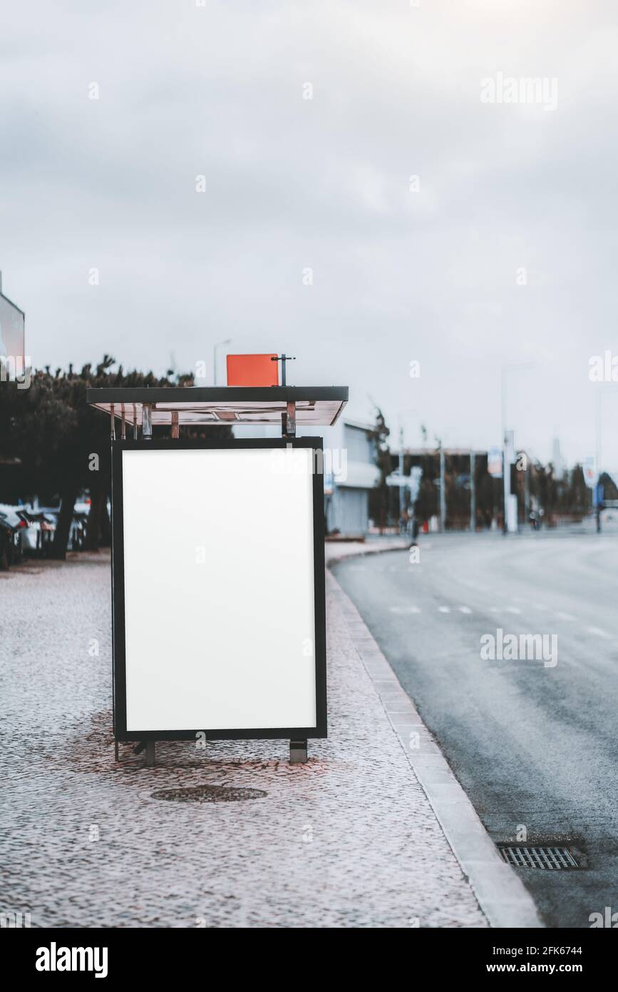 Vertical view of a bus stop with a placeholder white blank mockup of an ...