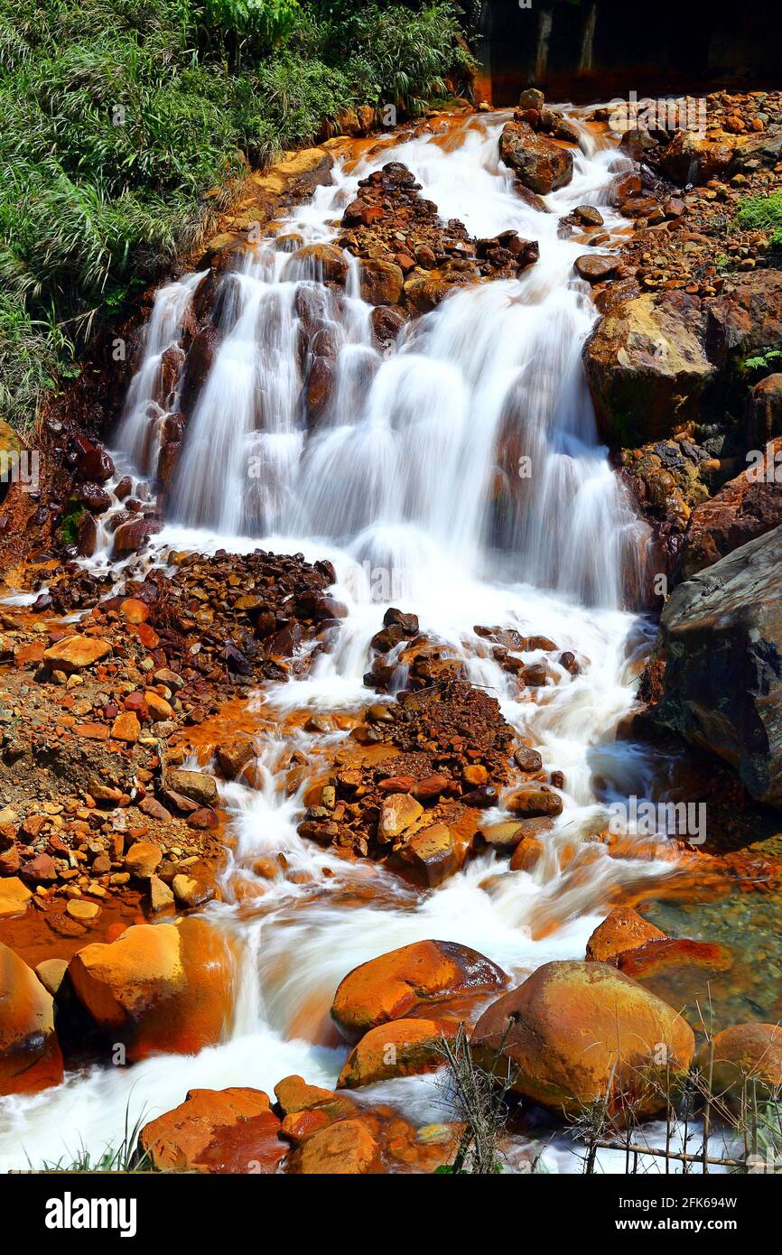 Golden Waterfall flowing over rust-colored rocks & soil due to minerals ...