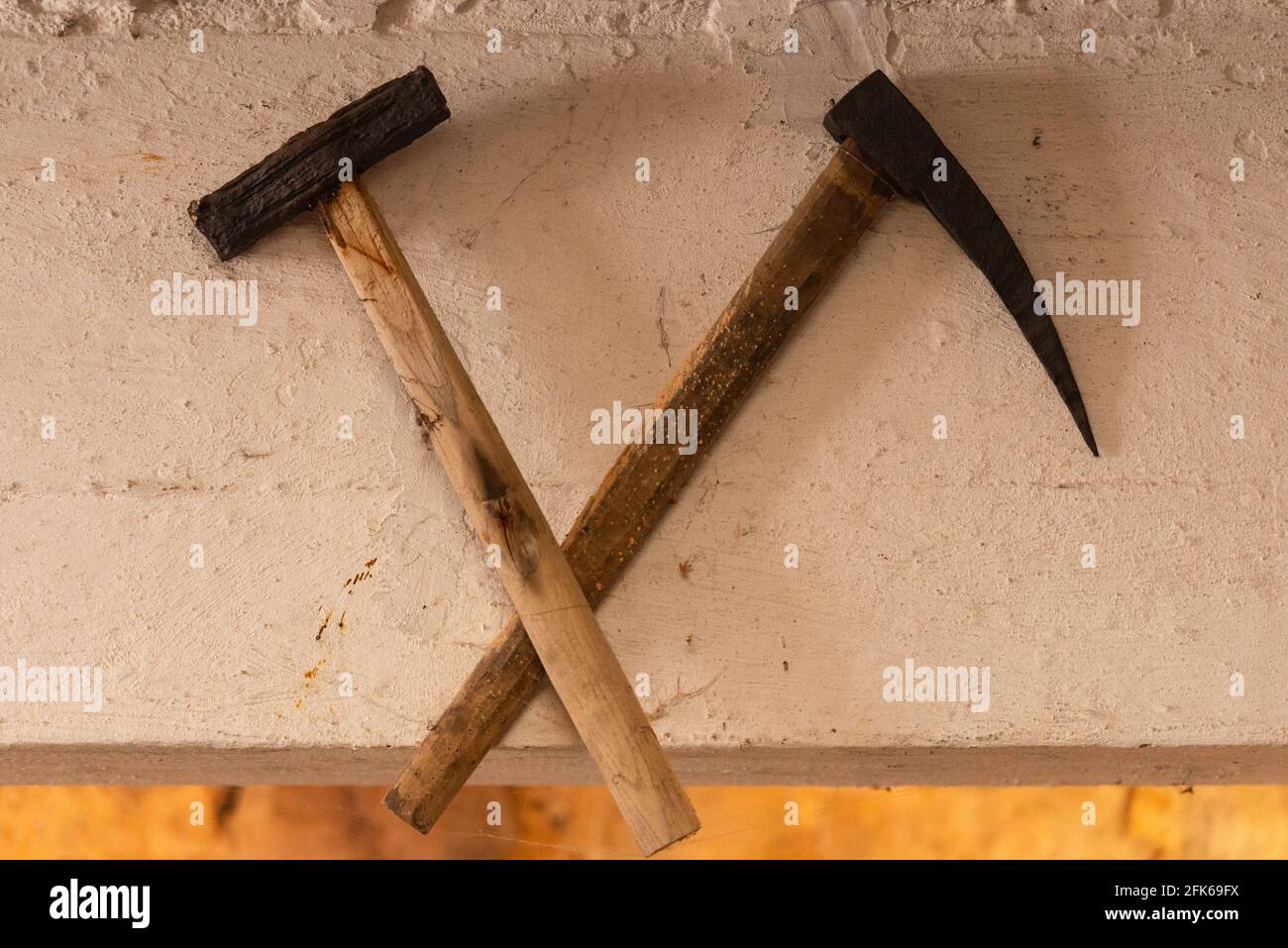 Hammer and ice pick on the wall of the house. Old tools left behind by ...