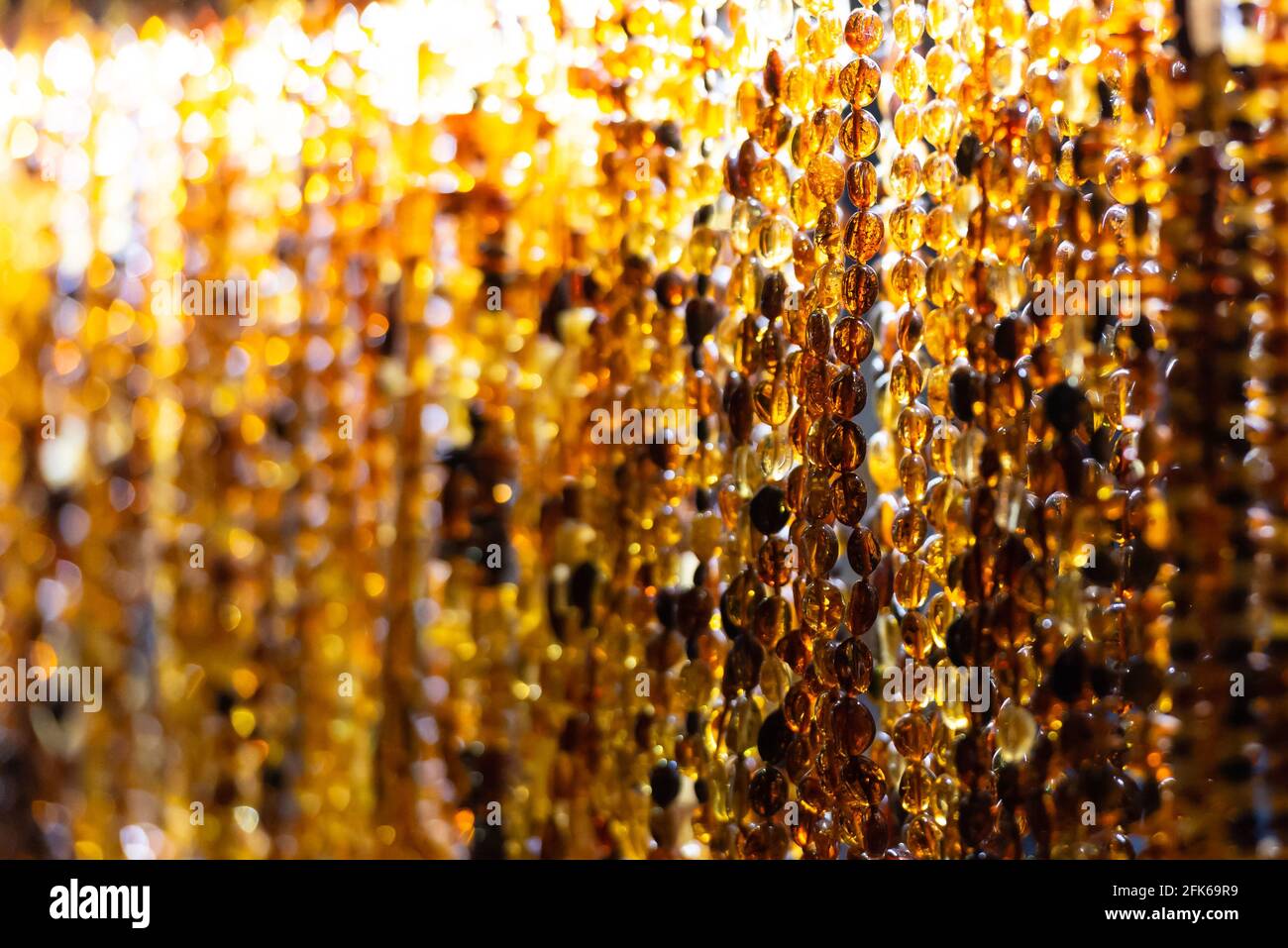 Polished amber beads. A wall of beads under a bright light. Beautiful ...