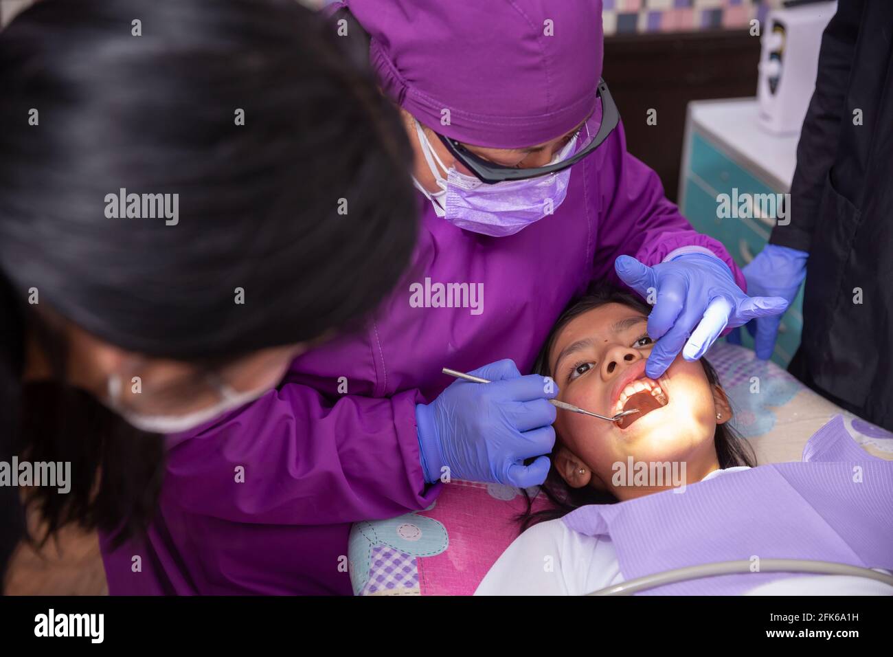 Mexican female dentist explaining the dental problems the young girl ...
