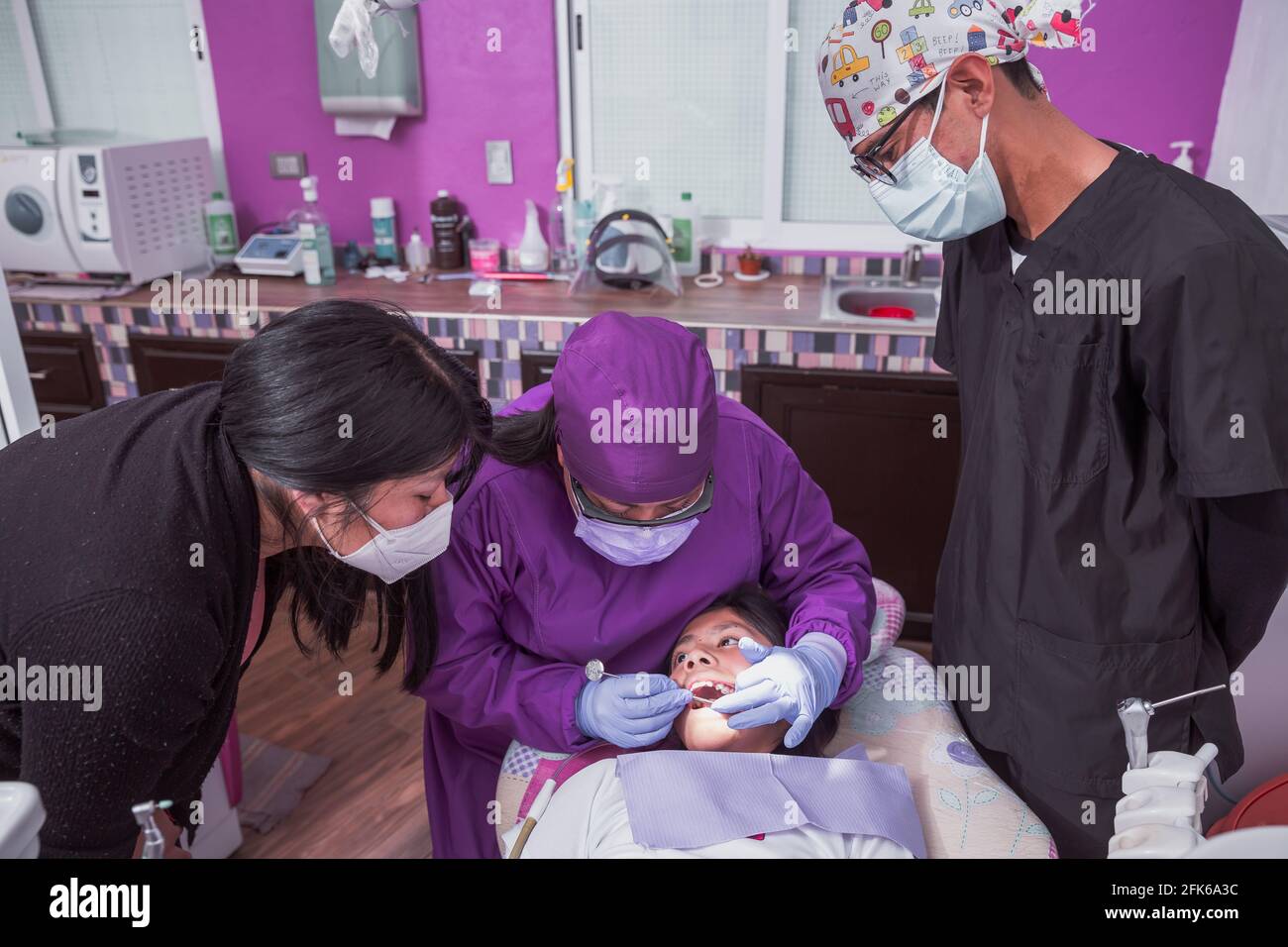 Mexican female dentist explaining the dental problems the young girl ...