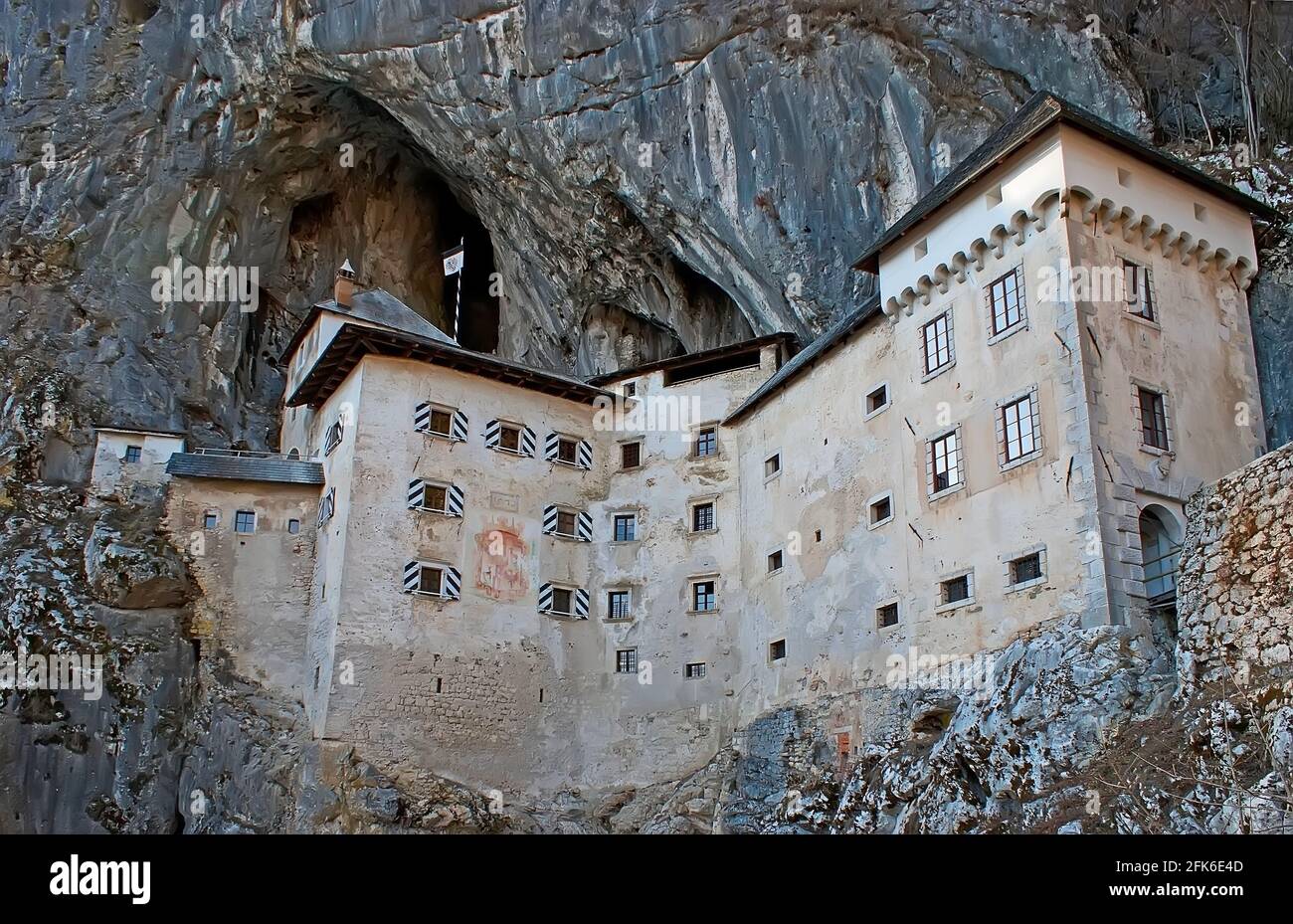 The medieval stone facade of Predjama Castle, built in the cave's mouth ...