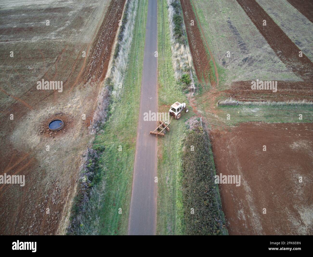 Tractor aerial view with country road and agricultural farming patterns ...