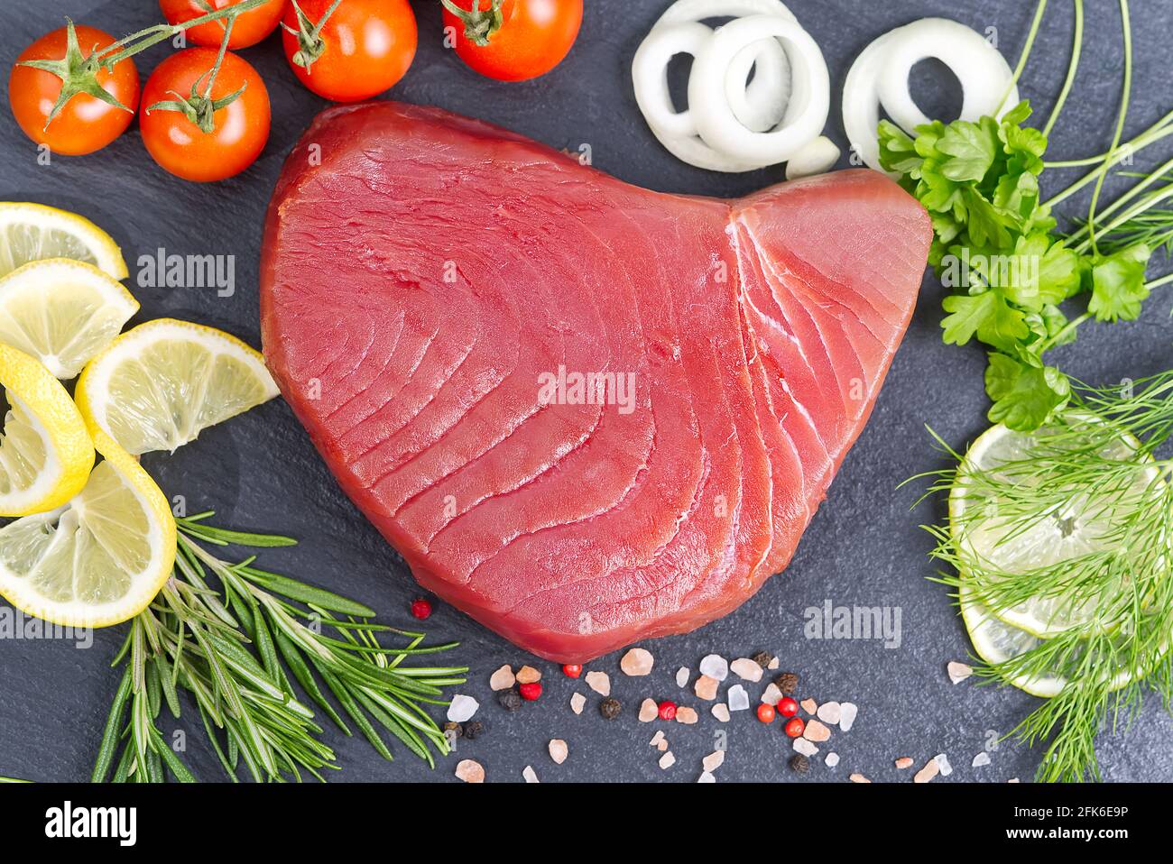 Raw fresh tuna slice in the kitchen and decorates with herbs and ...