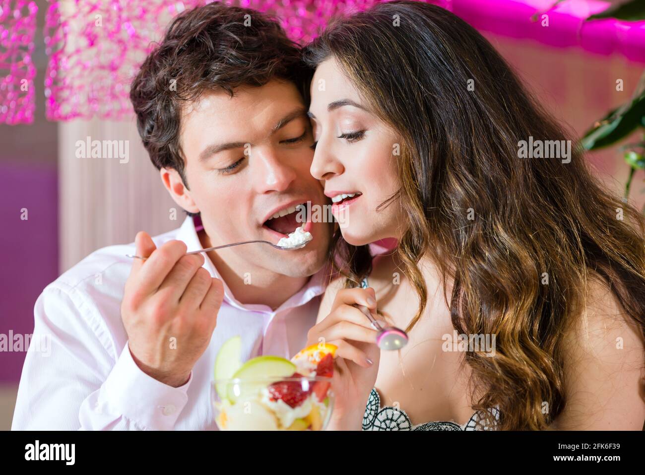 Young Couple in a Cafe or Ice cream parlor, eating an ice cream sundae ...