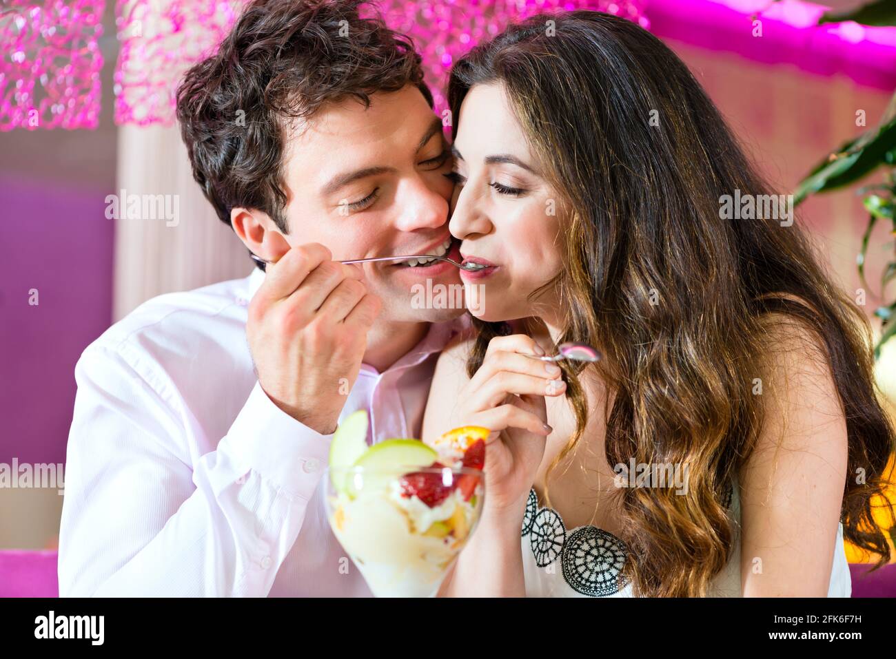 Young Couple in a Cafe or Ice cream parlor, eating an ice cream sundae ...