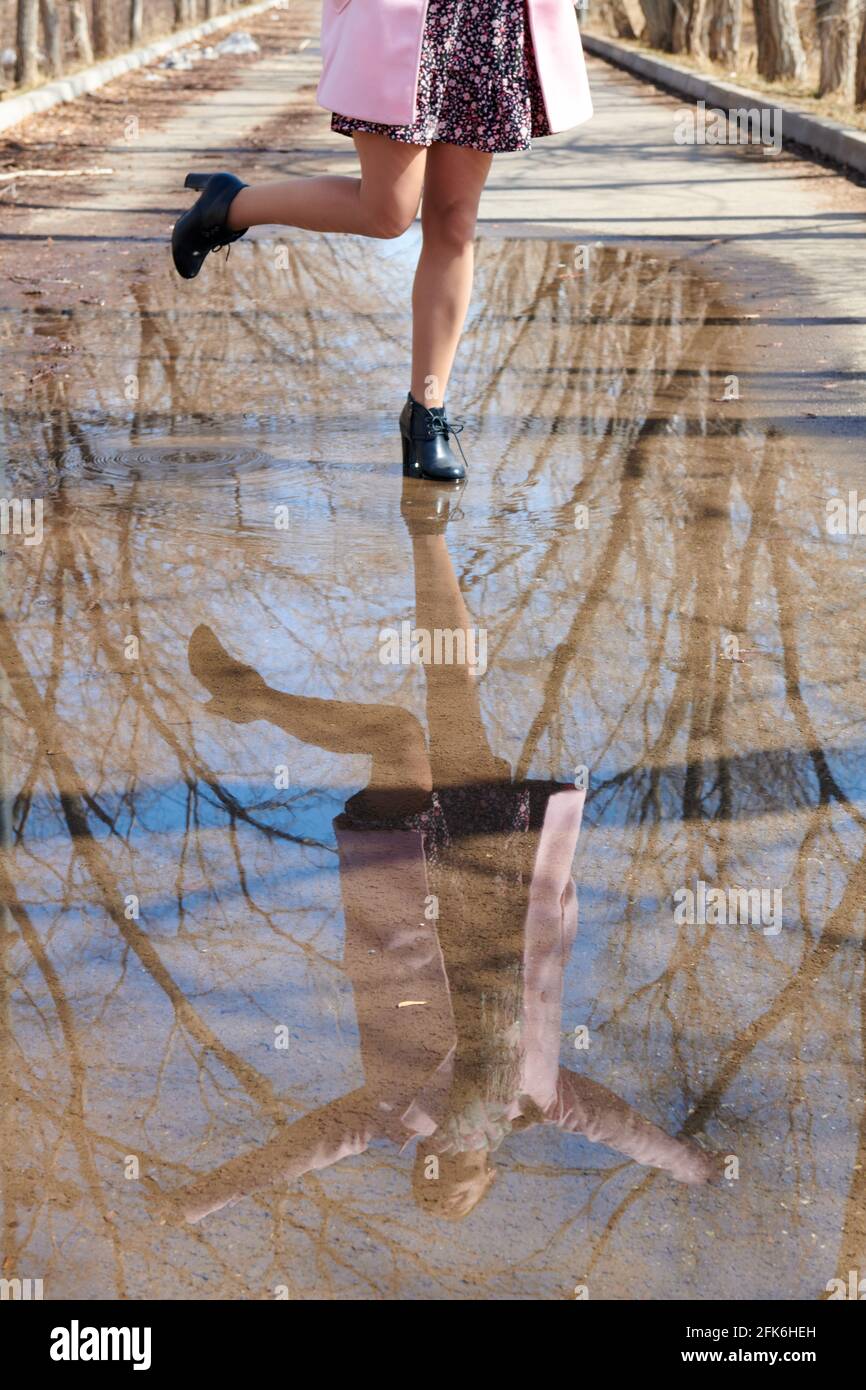 girl standing in a puddle with trees reflection Stock Photo - Alamy