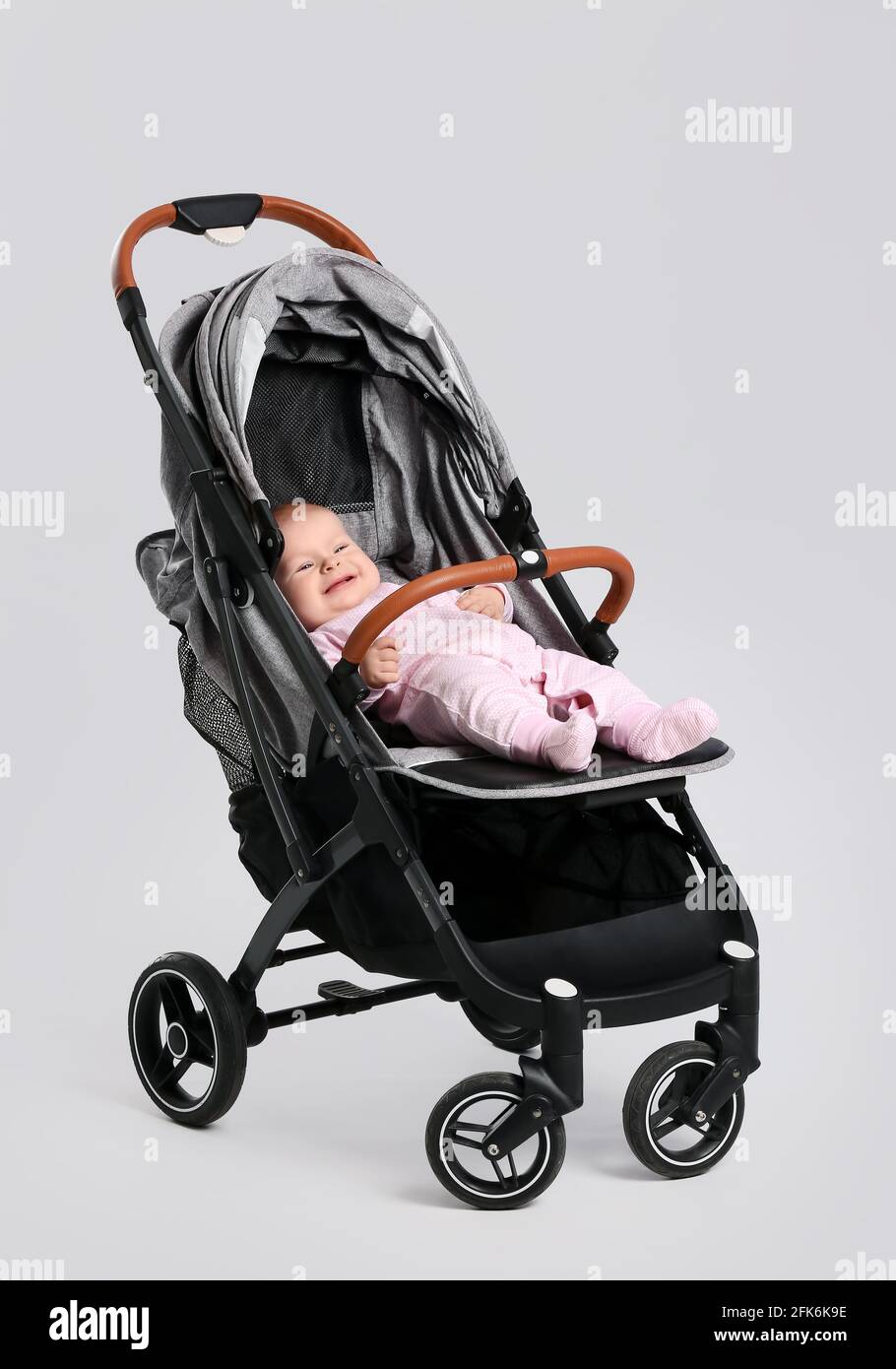 Cute little baby in stroller on white background Stock Photo - Alamy