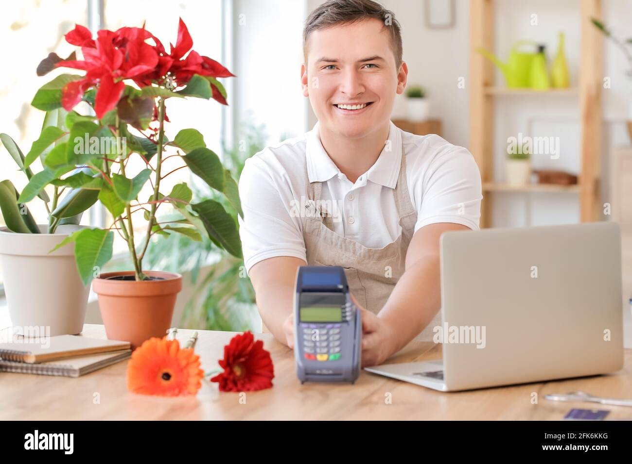 Seller with payment terminal in flower shop Stock Photo - Alamy