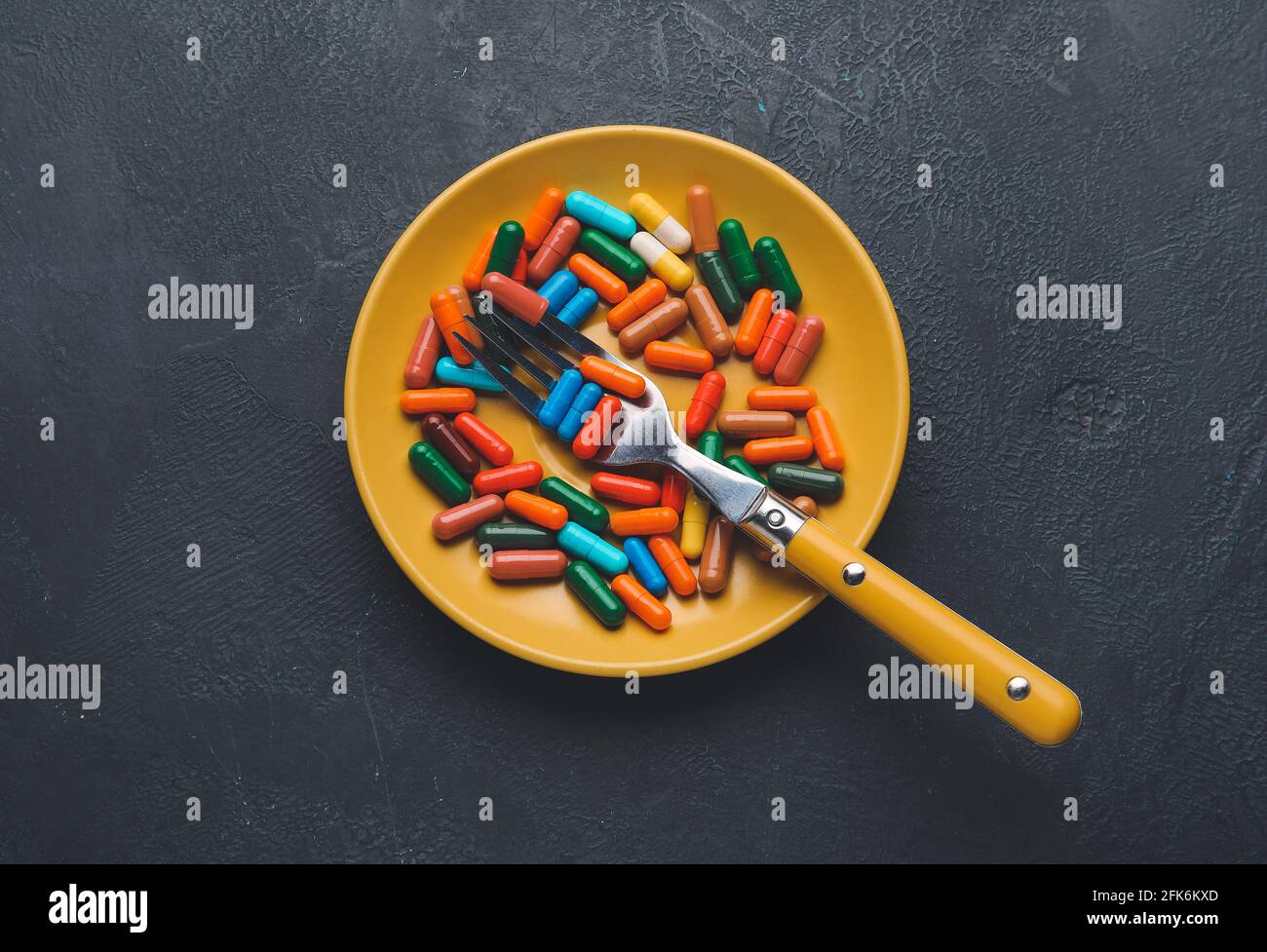 Plate and fork with different pills on dark background Stock Photo - Alamy