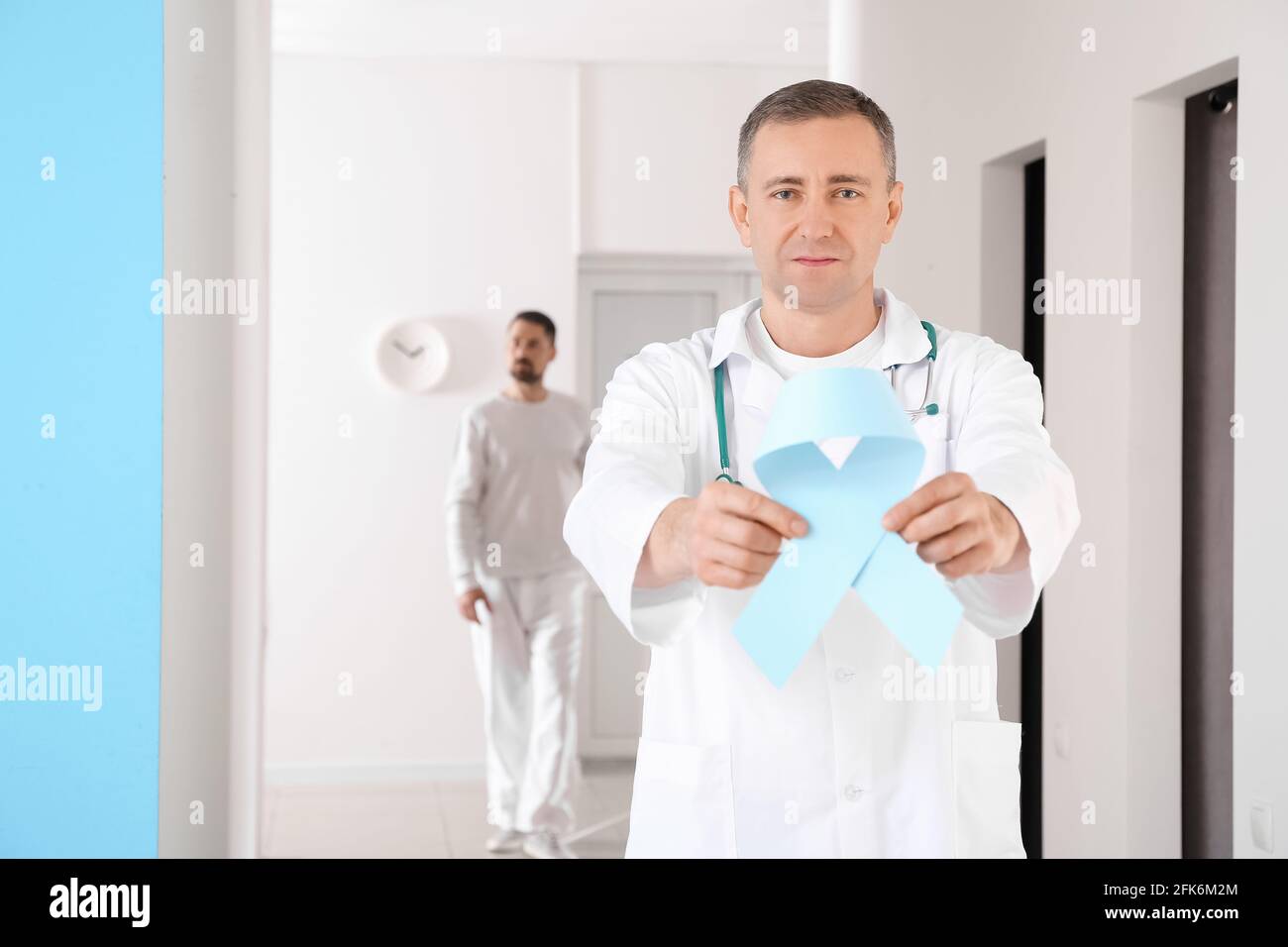 Oncologist with blue ribbon in clinic. Prostate cancer awareness ...