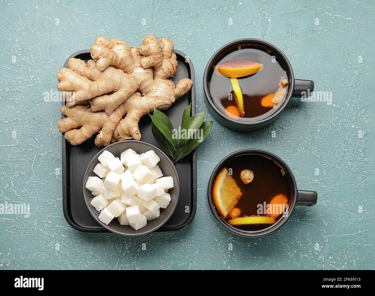 Composition with cups of tasty ginger tea and ingredients on color ...