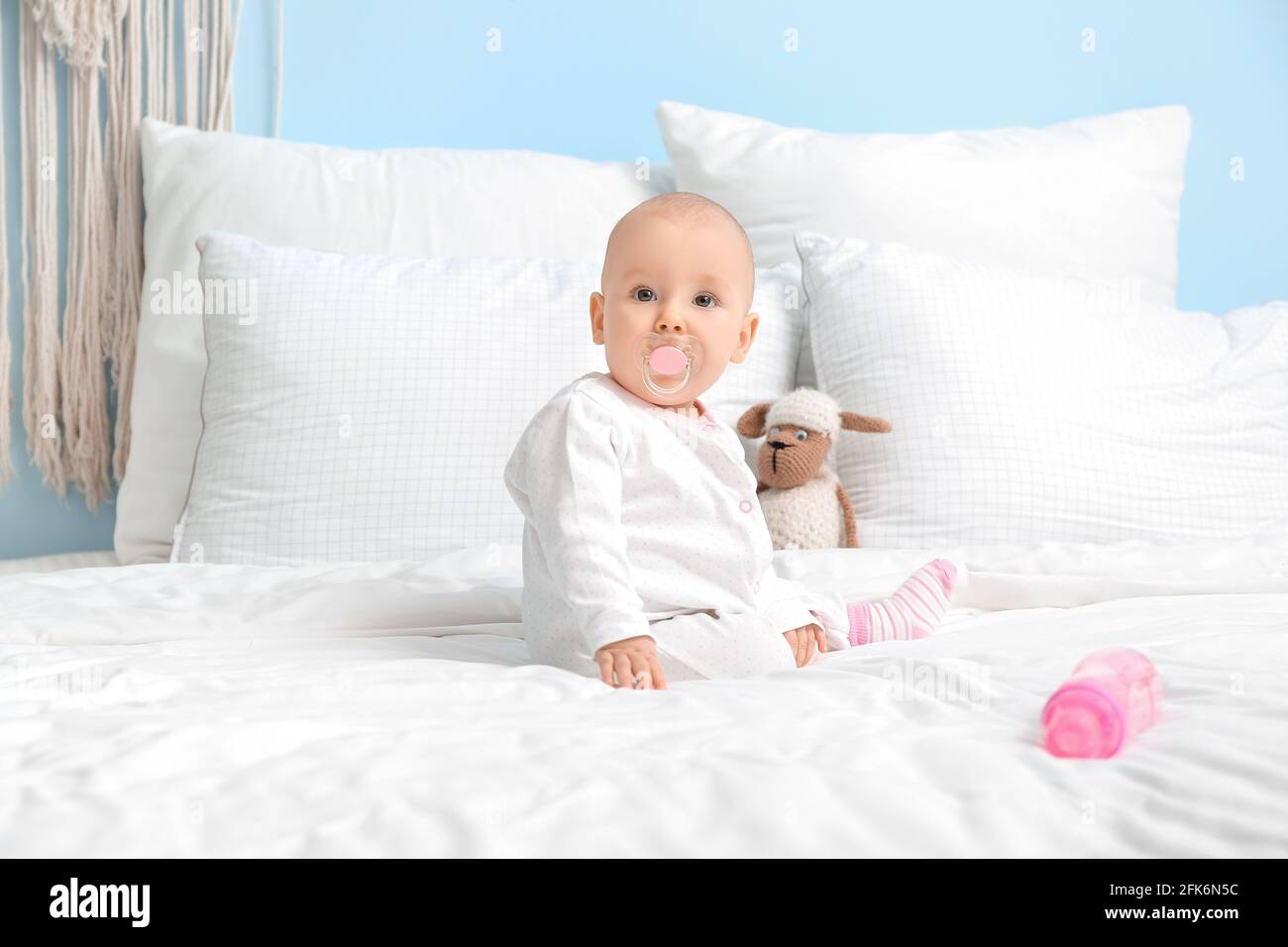 Cute little baby with bottle of water on bed in room Stock Photo - Alamy