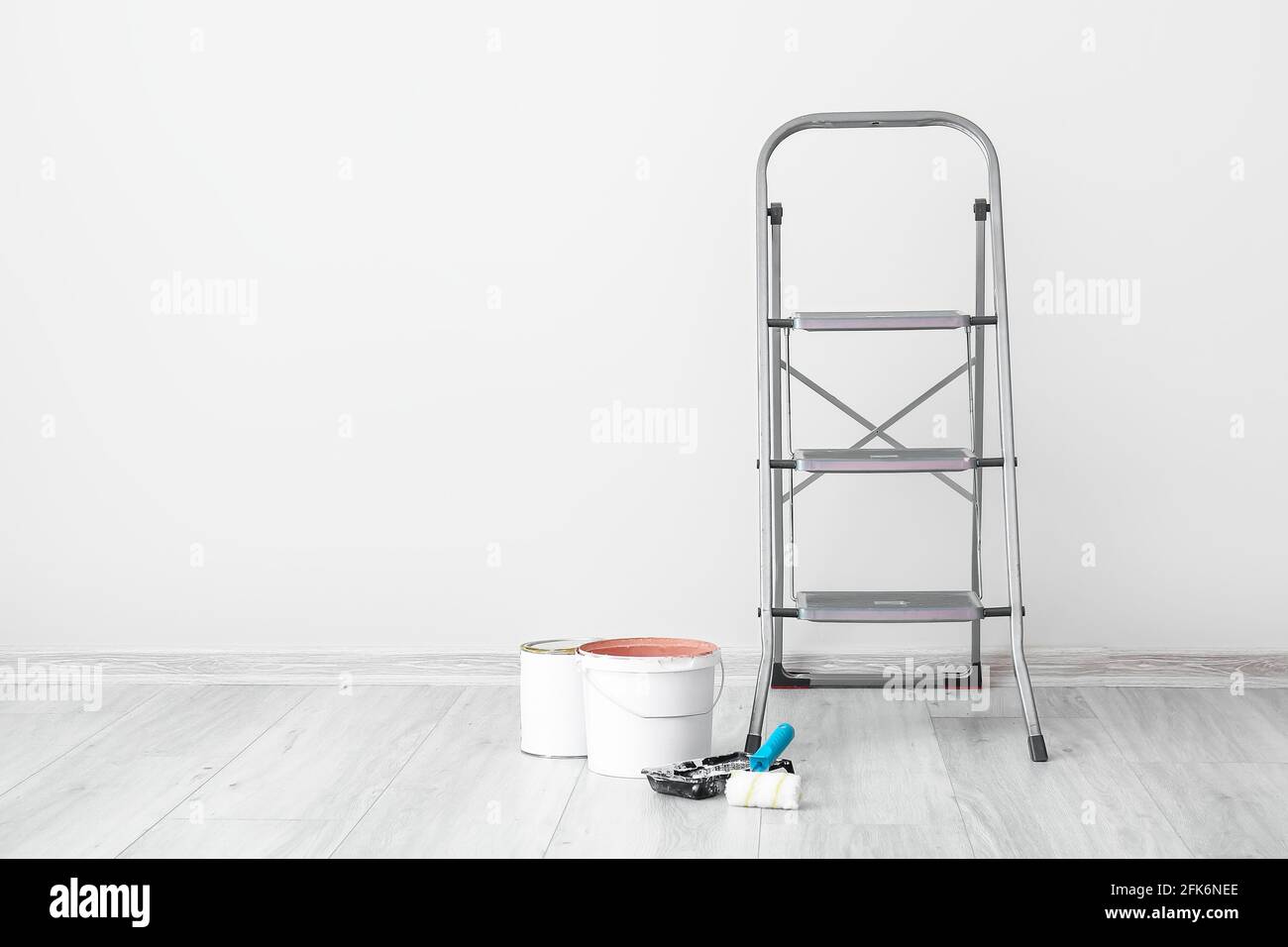 Ladder, buckets and roller near light wall Stock Photo - Alamy