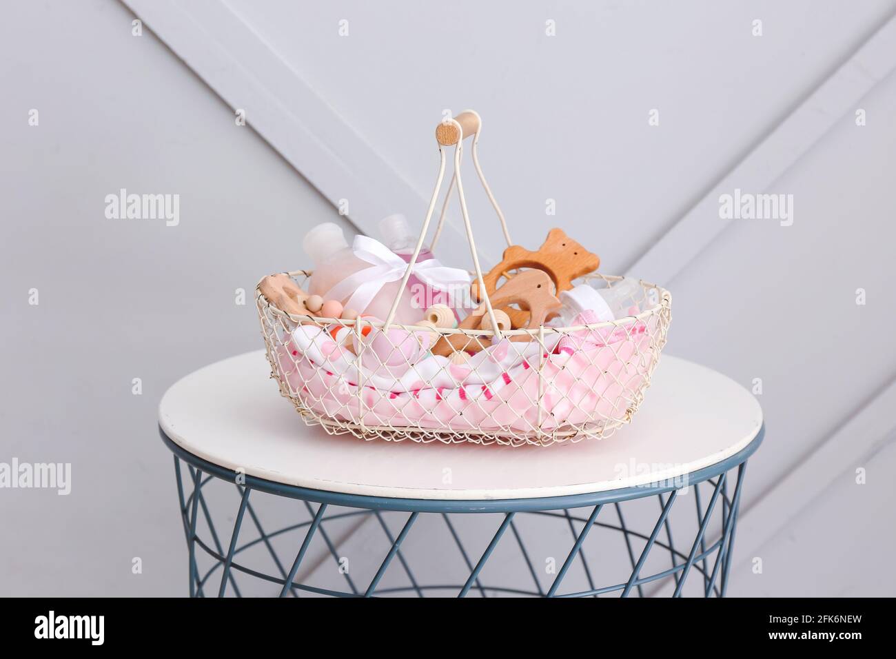 Table with gift basket for baby on light background Stock Photo - Alamy