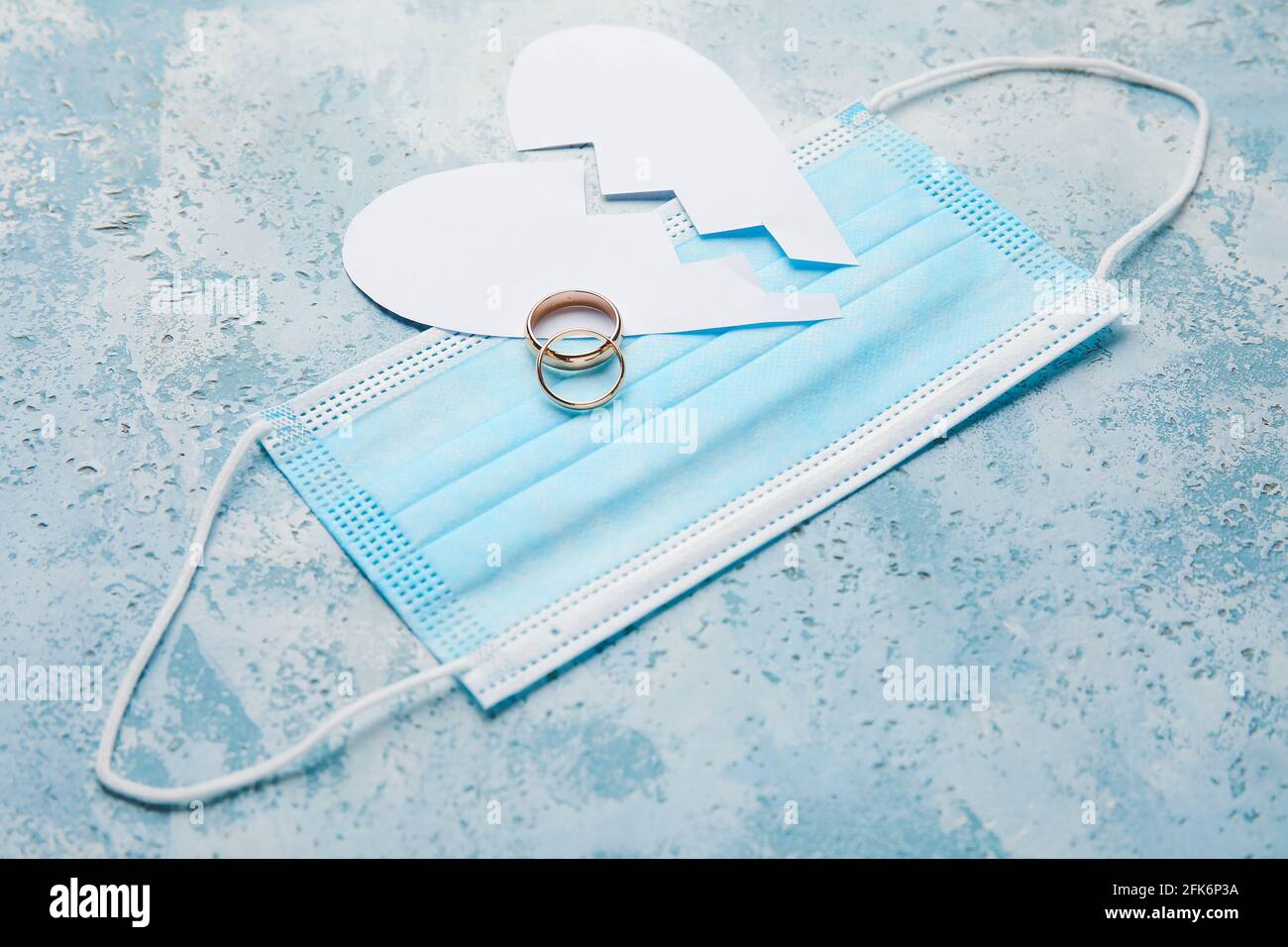 Broken heart with rings and mask on color background Stock Photo - Alamy