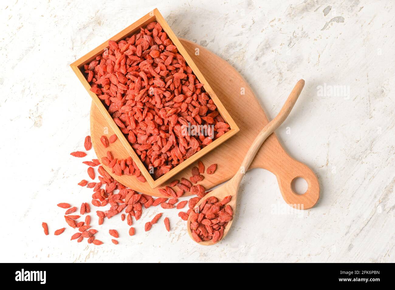 Box and spoon with dried goji berries on light background Stock Photo ...