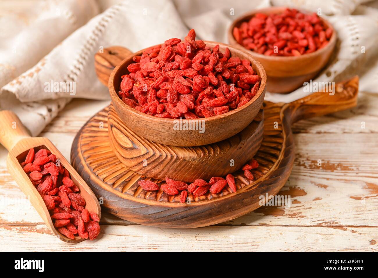 Bowl and scoop with dried goji berries on light wooden background Stock ...