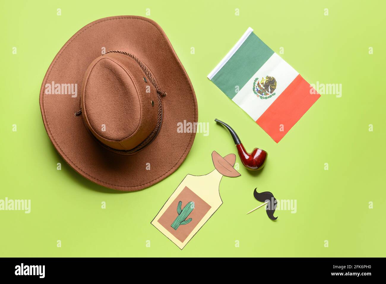 Composition with Mexican flag, hat and smoking pipe on color background ...