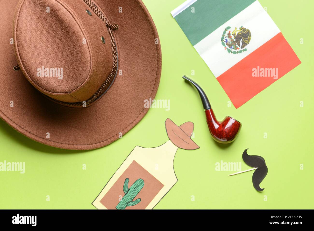 Composition with Mexican flag, hat and smoking pipe on color background ...