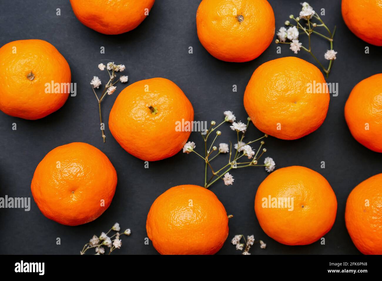 Sweet tangerines and flowers on dark background, closeup Stock Photo ...