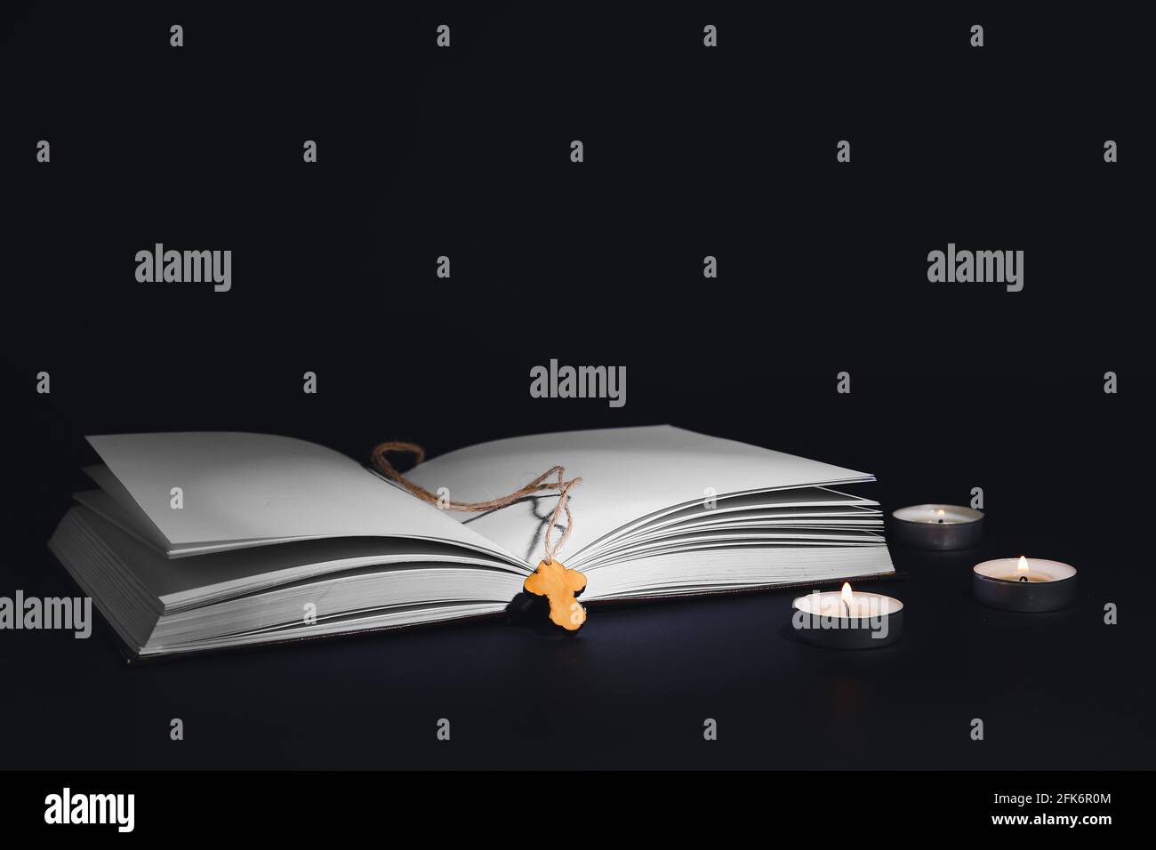 Wooden cross with book and candles on dark background Stock Photo - Alamy