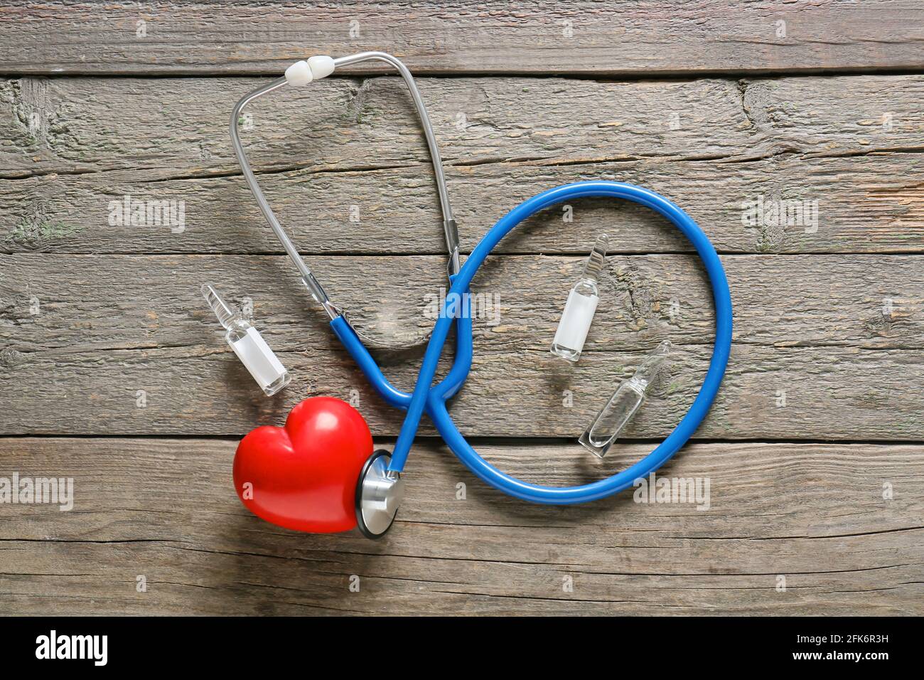 Modern stethoscope with heart and ampules on wooden background Stock ...