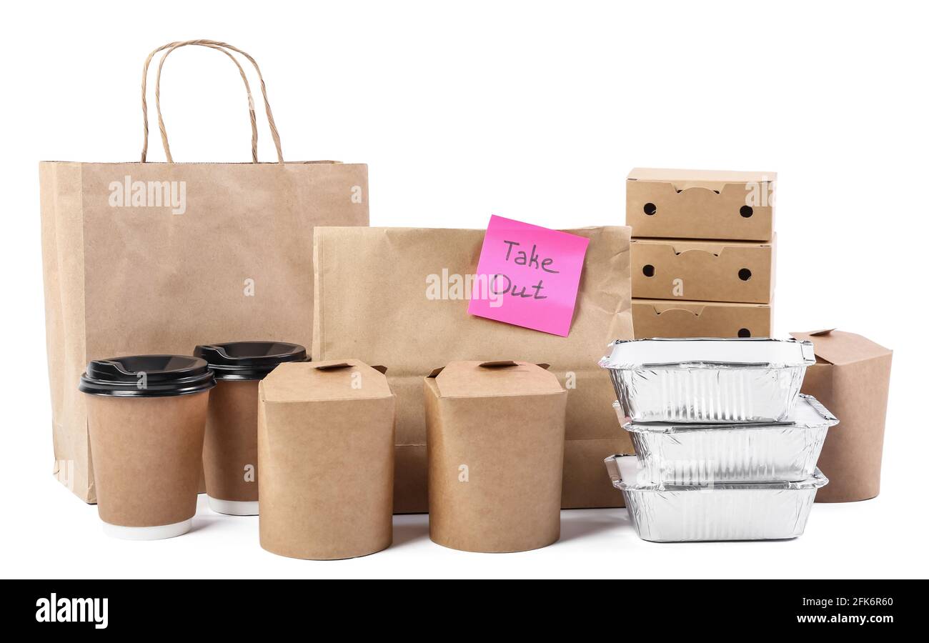 Paper bags with sticker TAKE OUT, containers for food and cups on white ...
