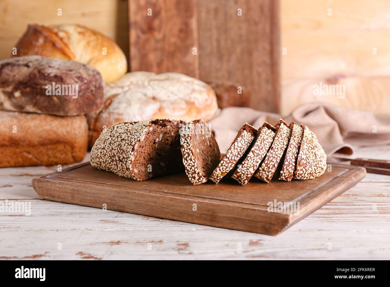 Board with fresh cut bread on light wooden background Stock Photo - Alamy